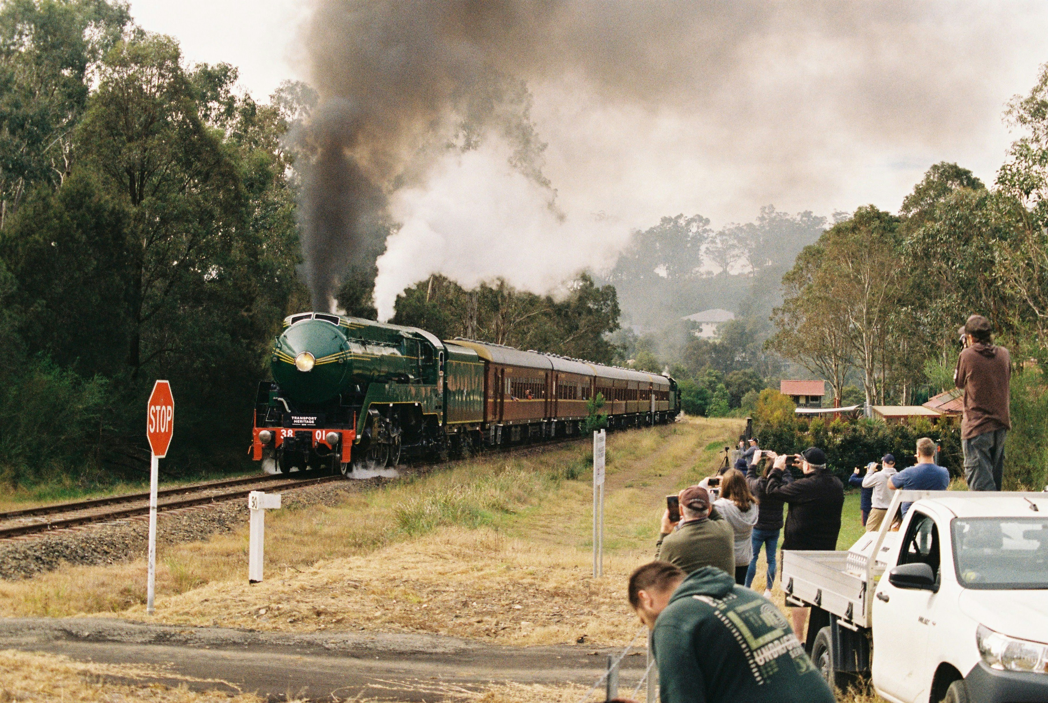 Green Steam Locomotive Rounds the Curve as Crowd Gathers by the Tracks