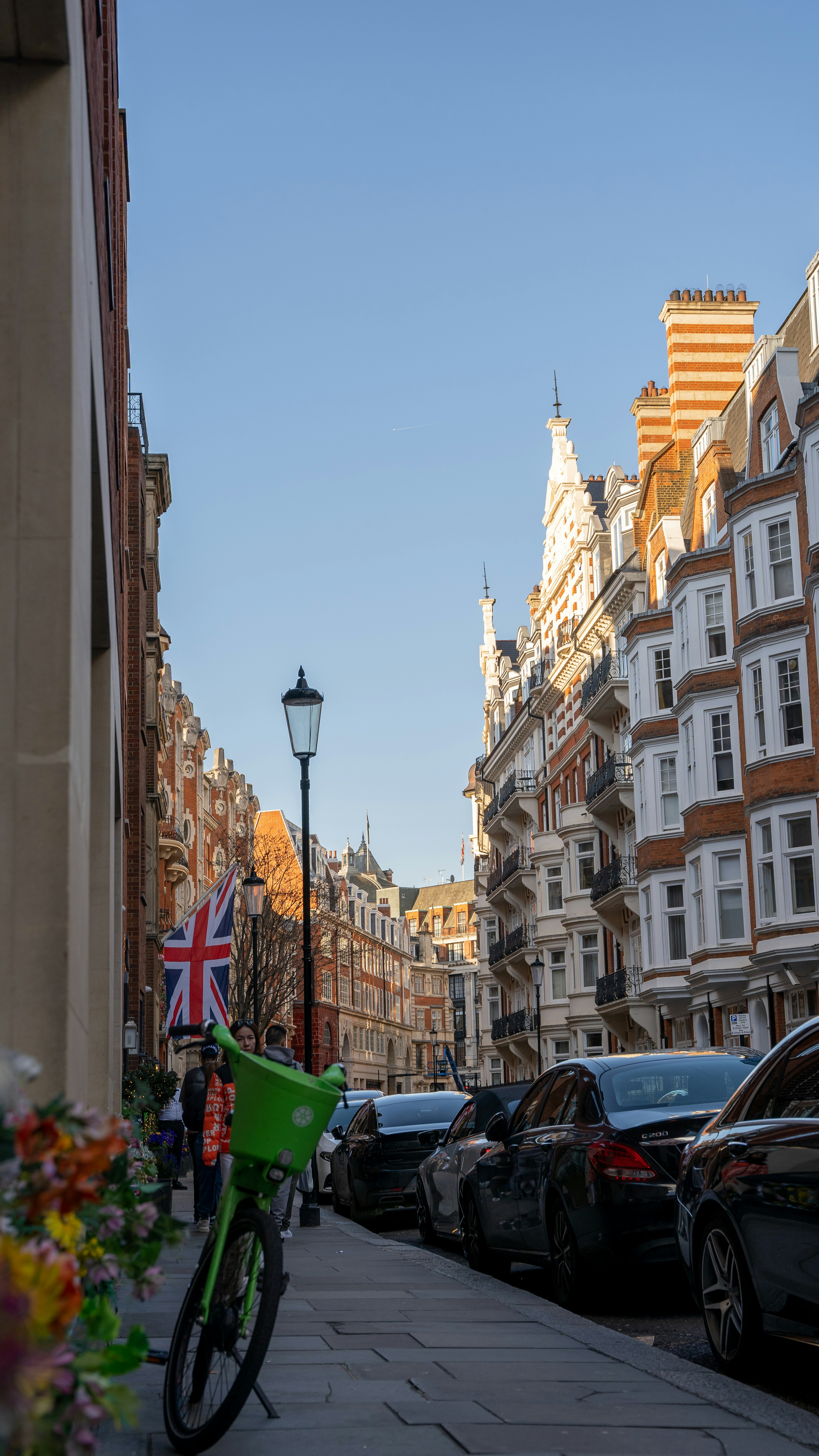 London Street Clock and Flag: A Quiet Moment Between Bright Facades