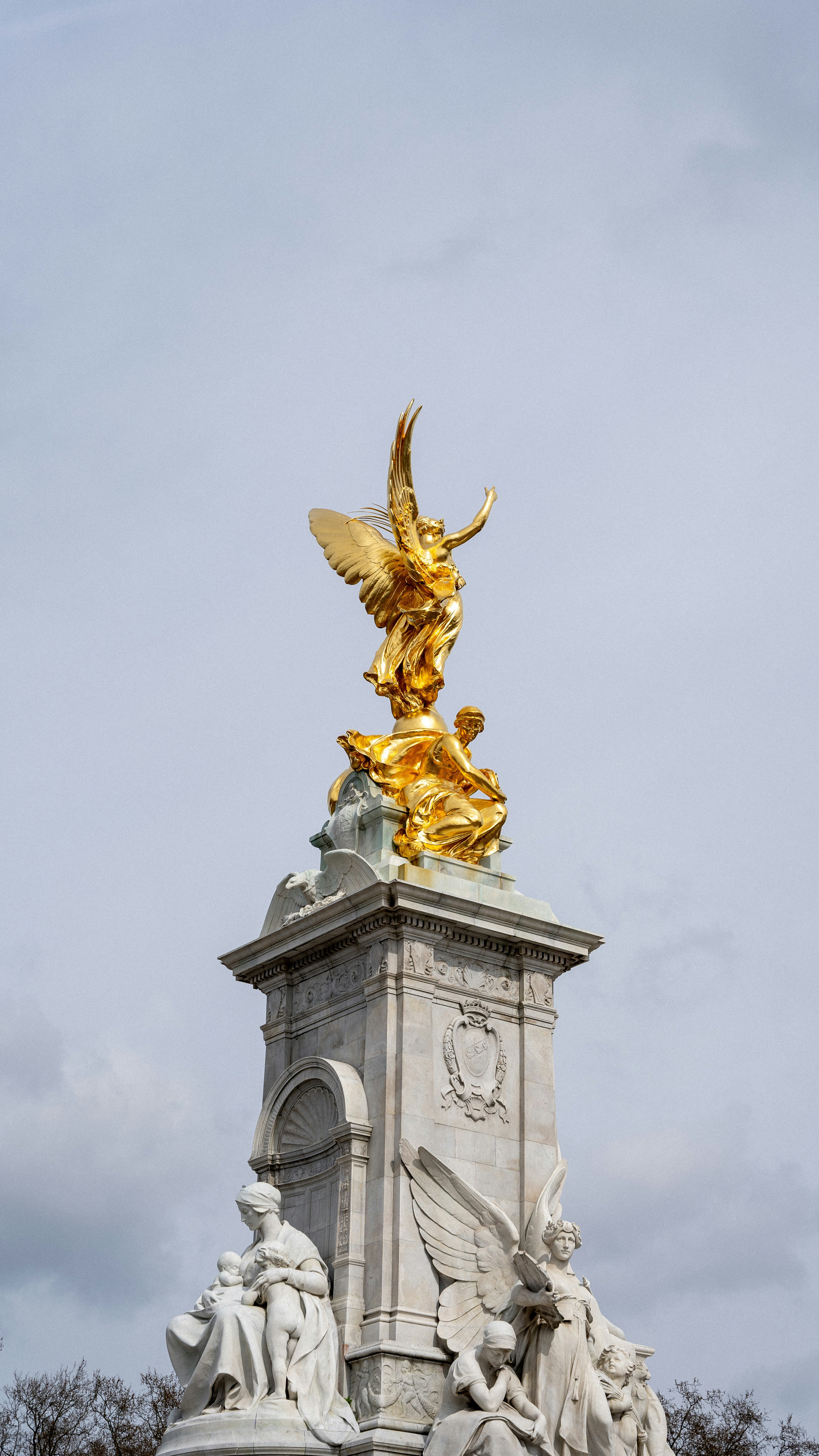 a golden statue on top of a white monumentHarrison Mitchell
