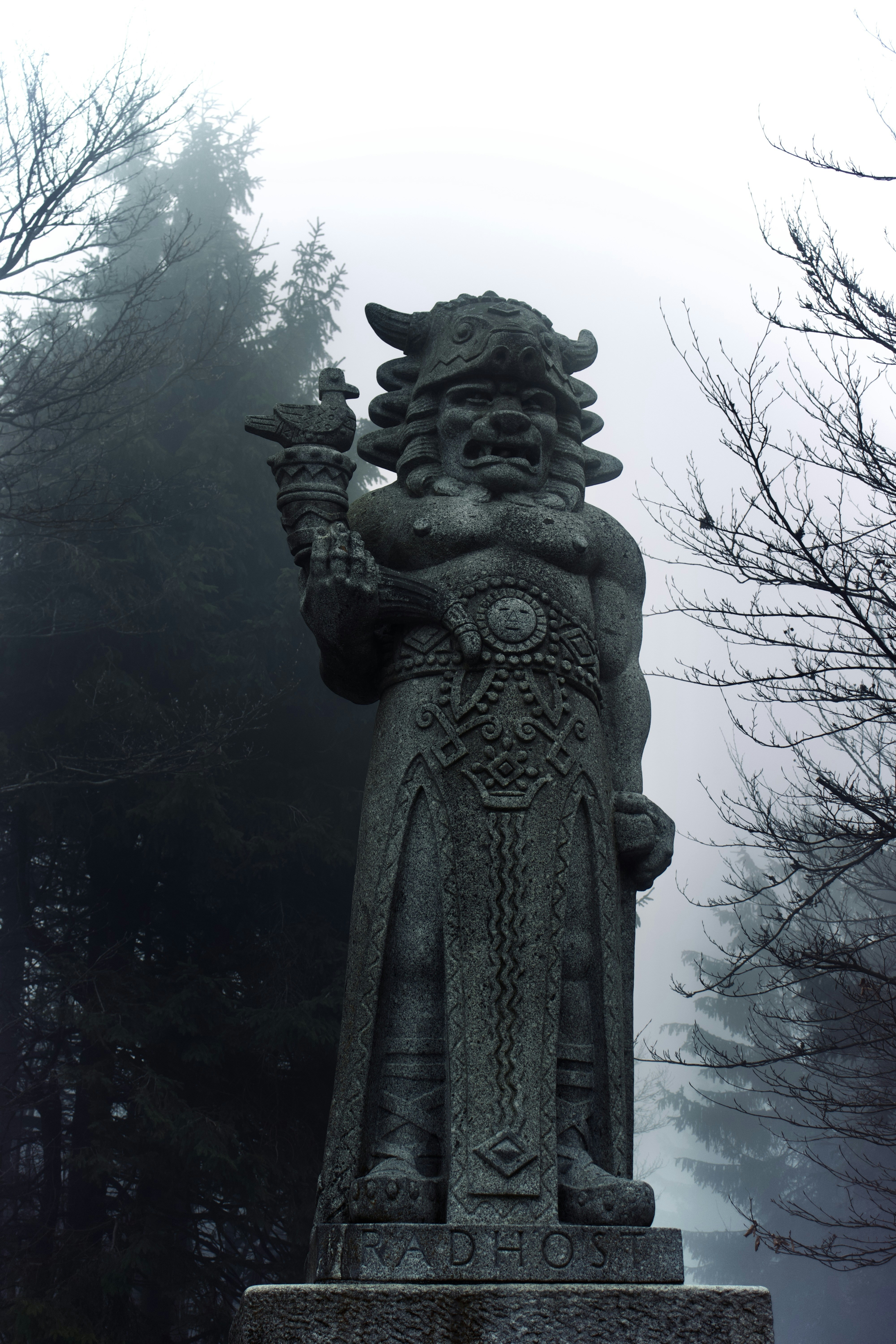 Mistbound Sentinel: A Torch-Bearing Stone Guardian in Fog Among Pines