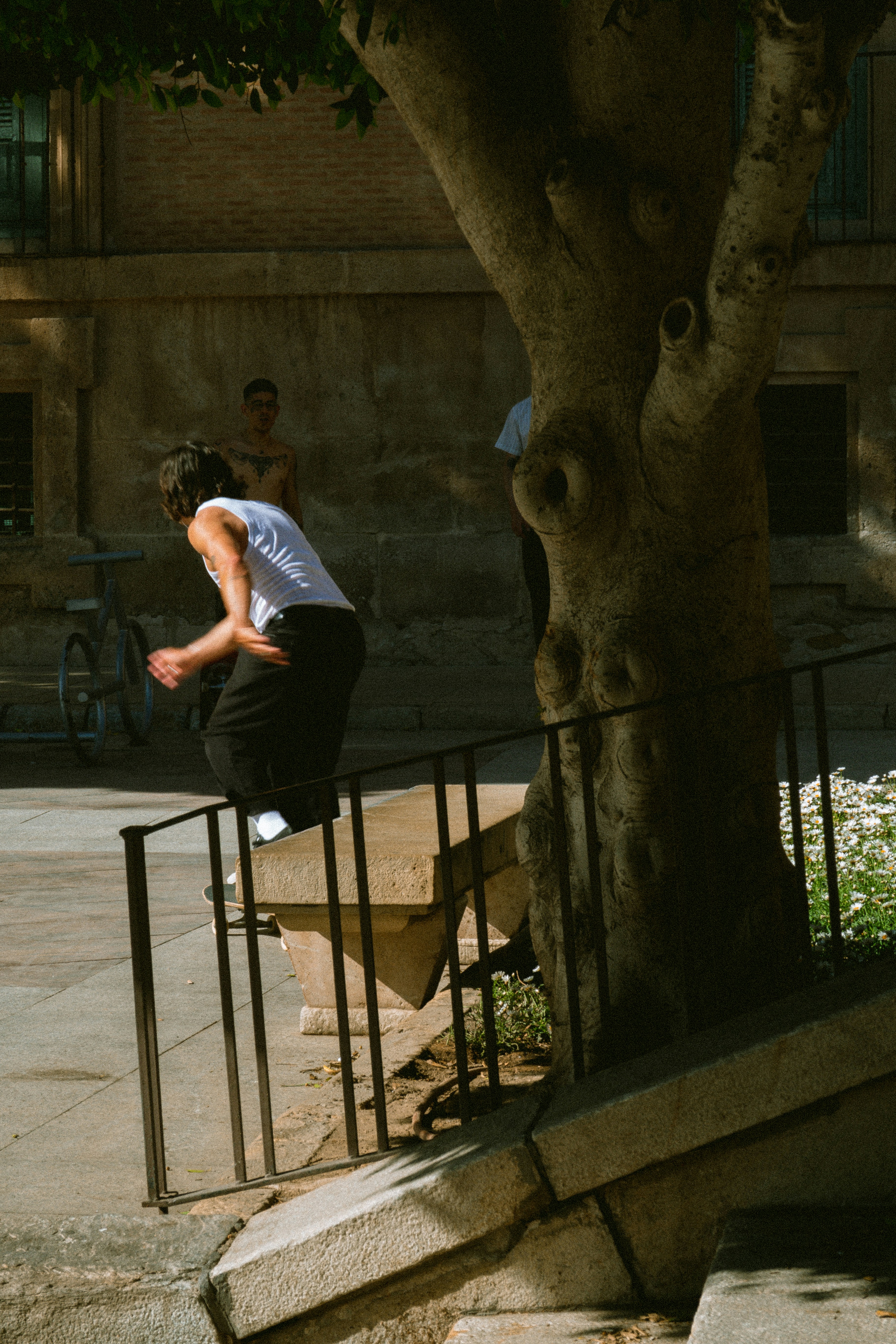 Midair over the Rail: Street Acrobat in a Sunlit Courtyard