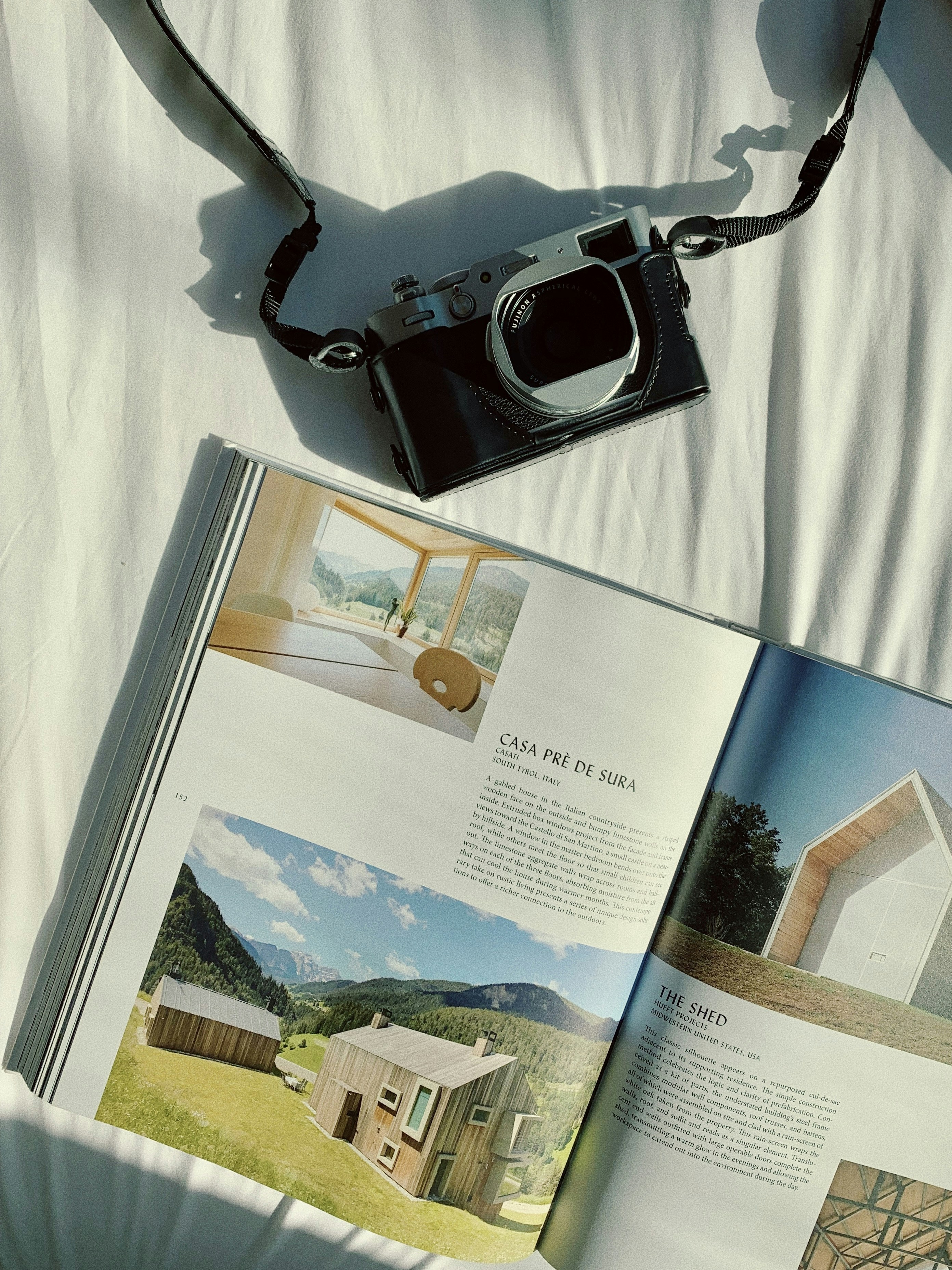 a camera and a book laying on a bed