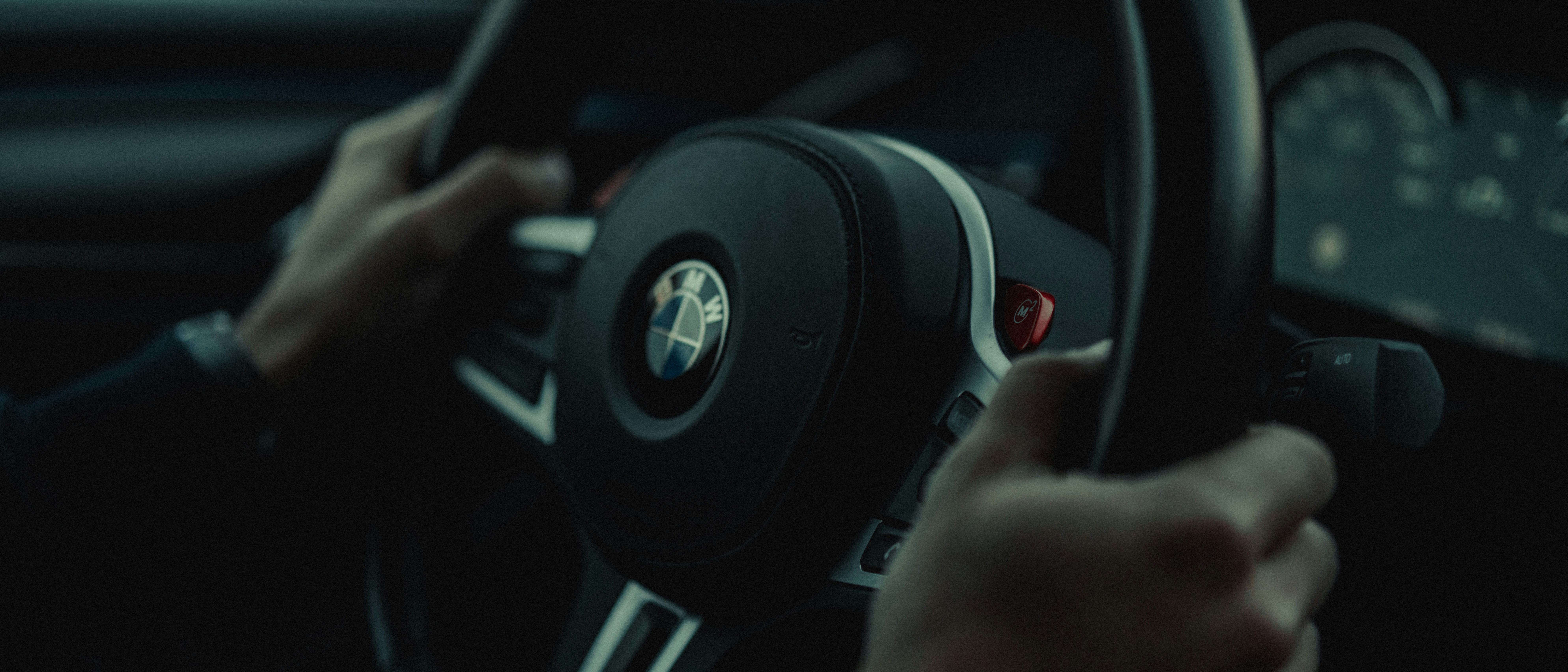 Low-Light Pulse: BMW Steering Wheel in Dim Cockpit Glow