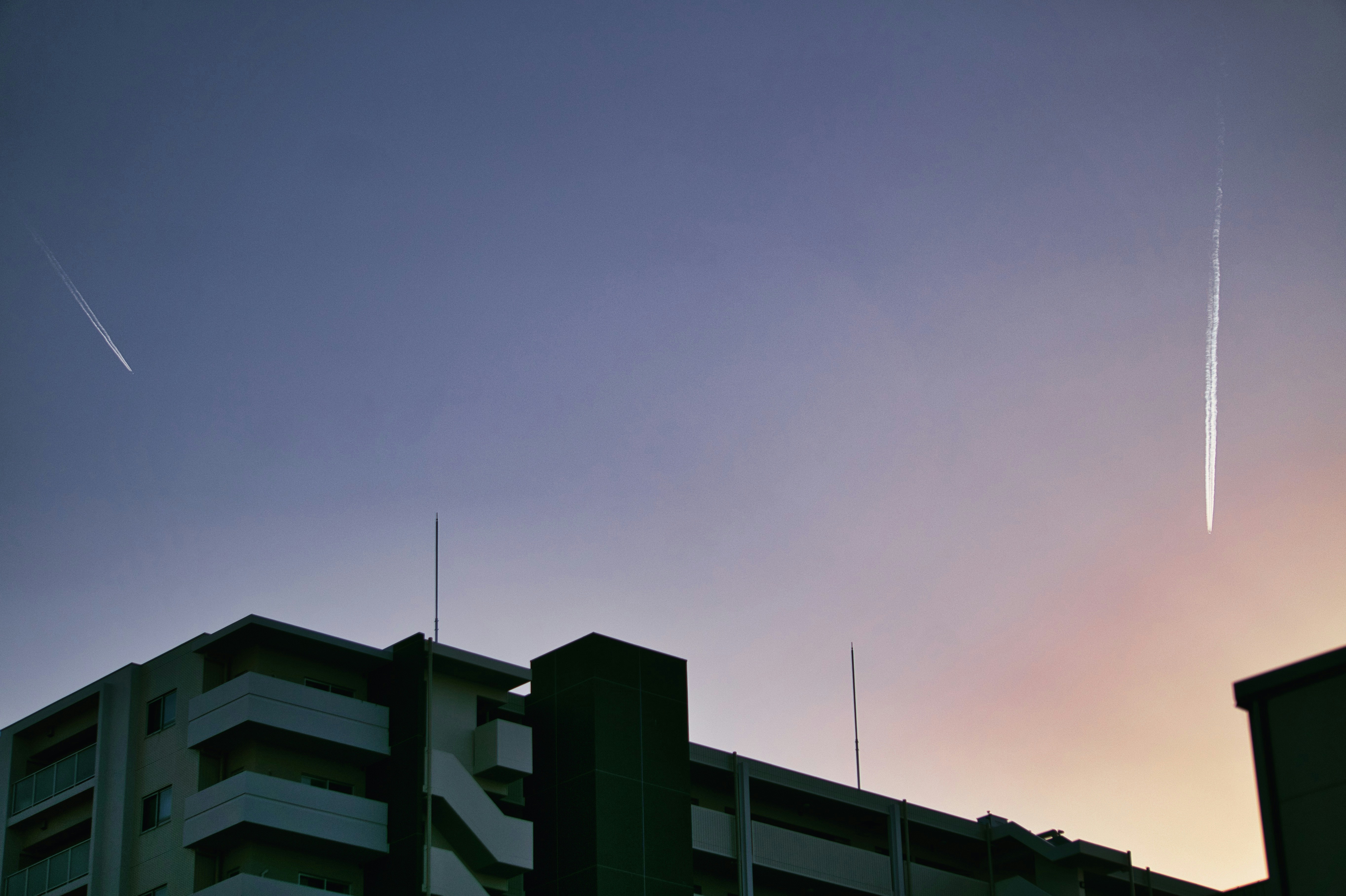 Dusk over the City: Contrails Trace the Quiet Horizon