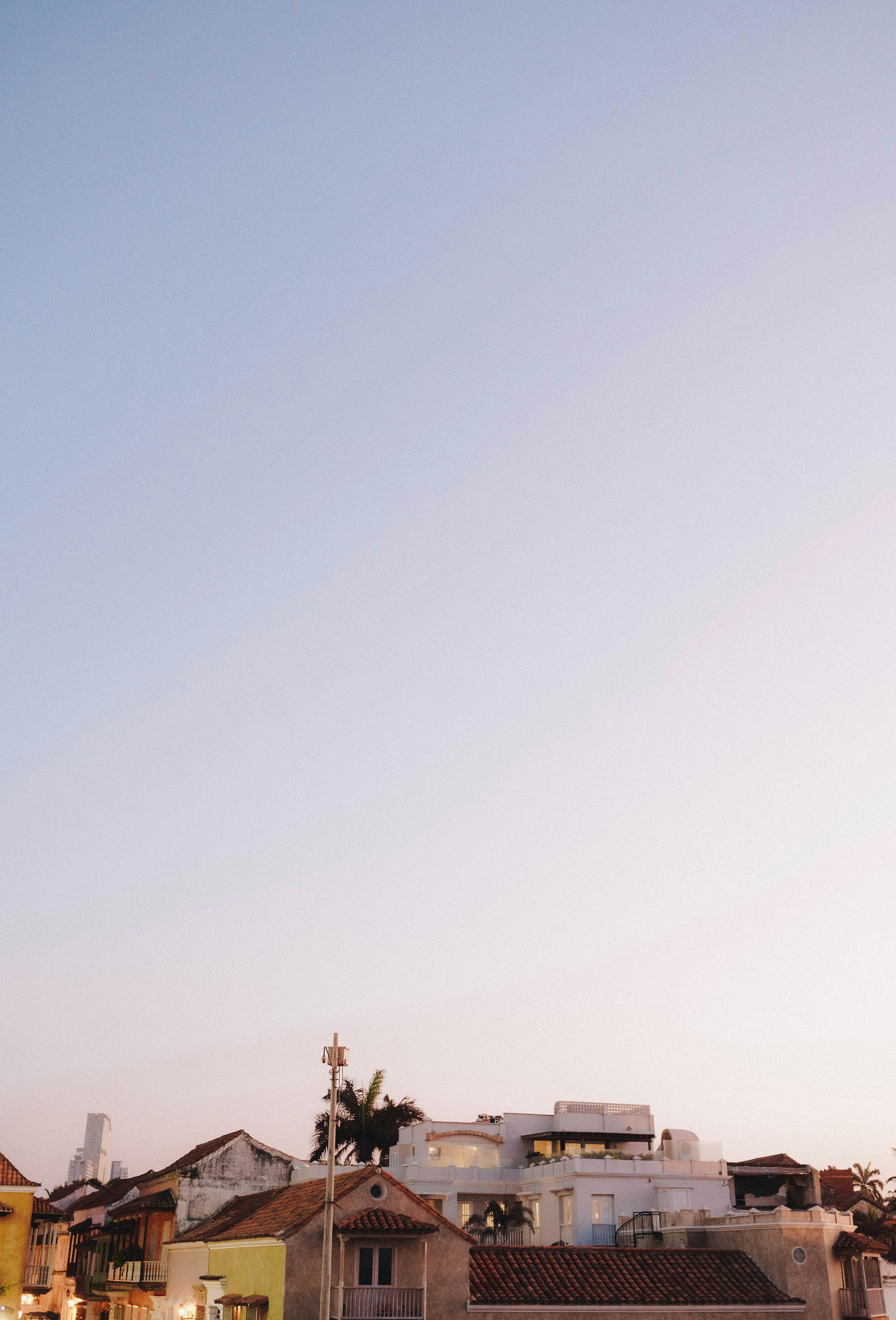 City rooftops silhouetted against a pastel evening sky.