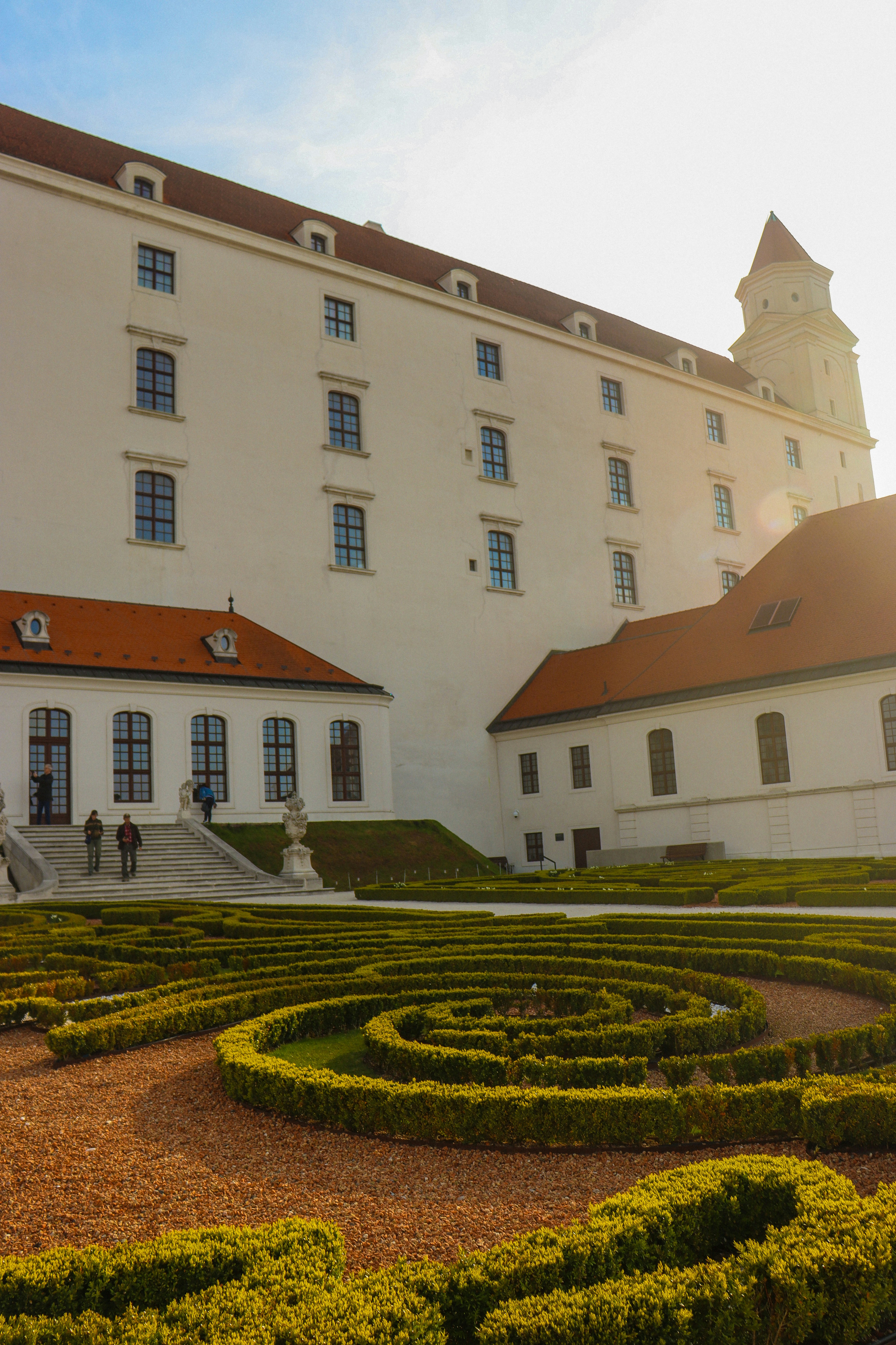 Sunlit Castle Facade Overlooking Curving Topiary