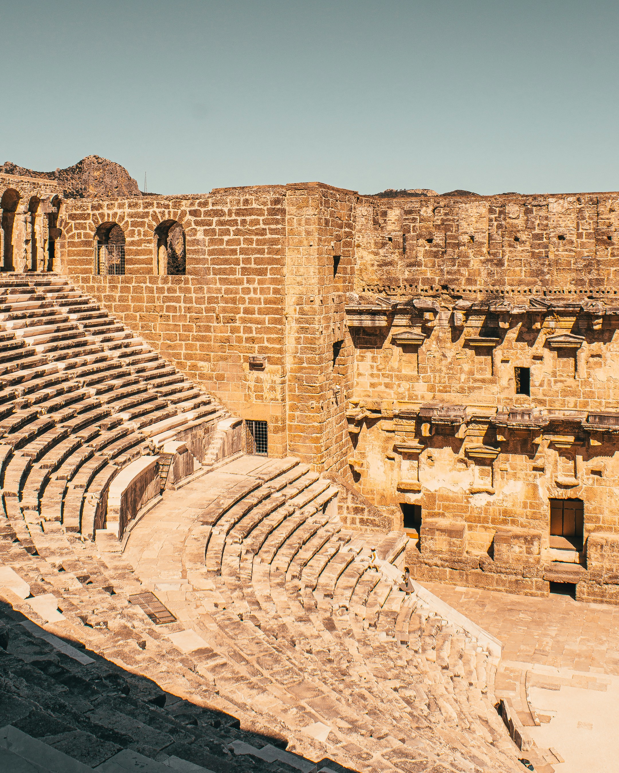 A large stone building with a bunch of seats on top of it photo – Free ...