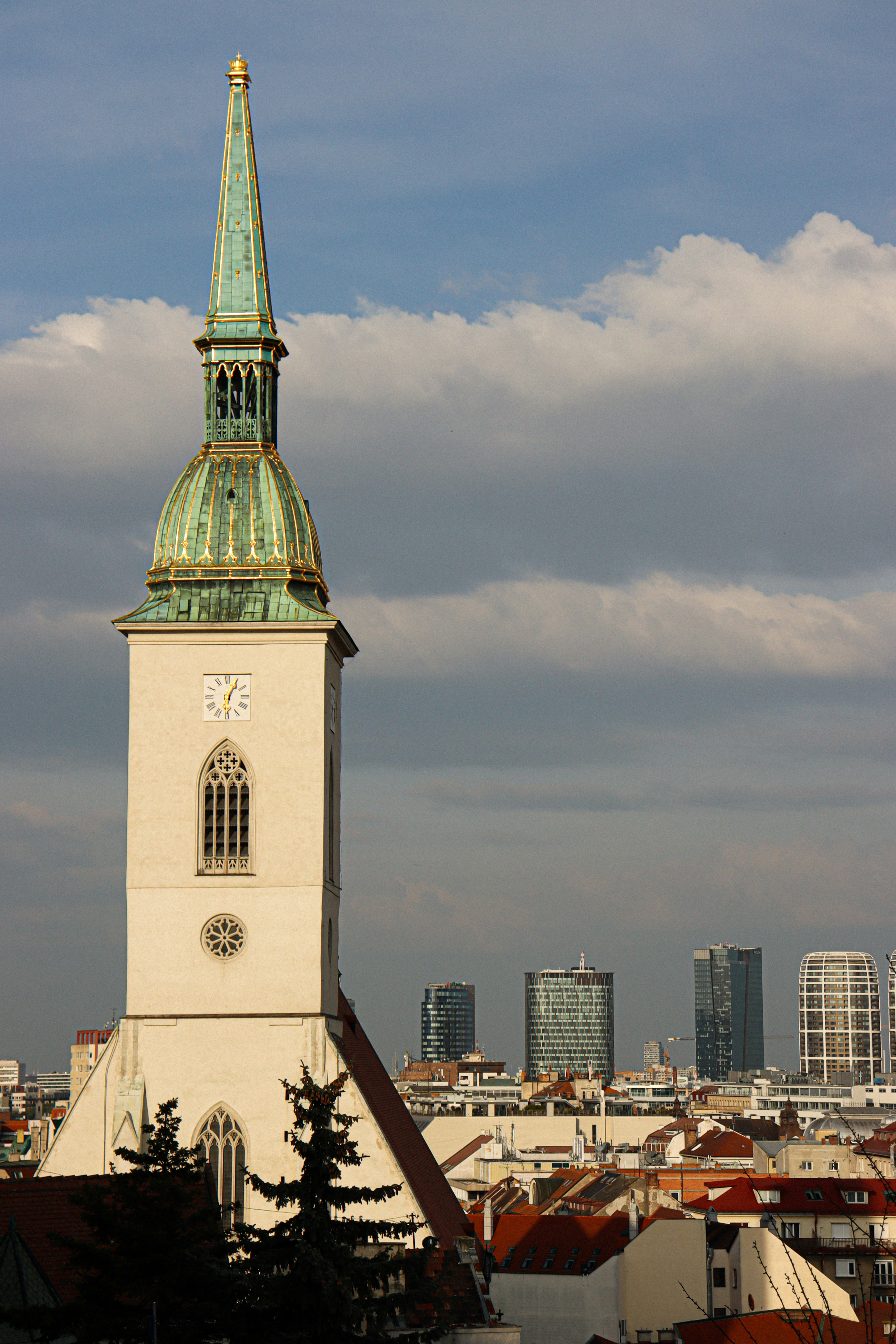 Verdigris Spire Over a Modern Cityscape