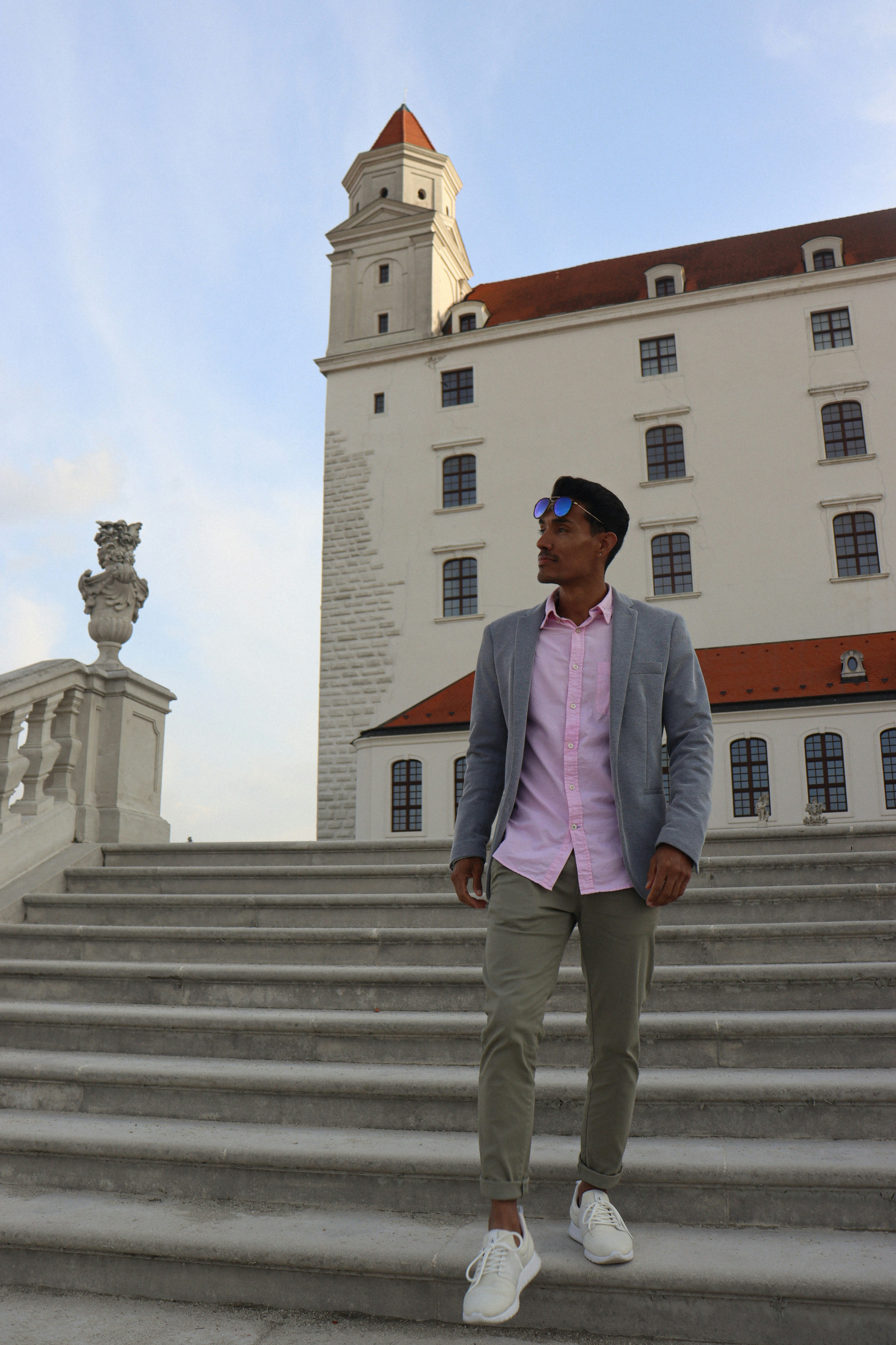 Dapper Figure on Castle Steps: A Quiet Moment Against a Historic Façade