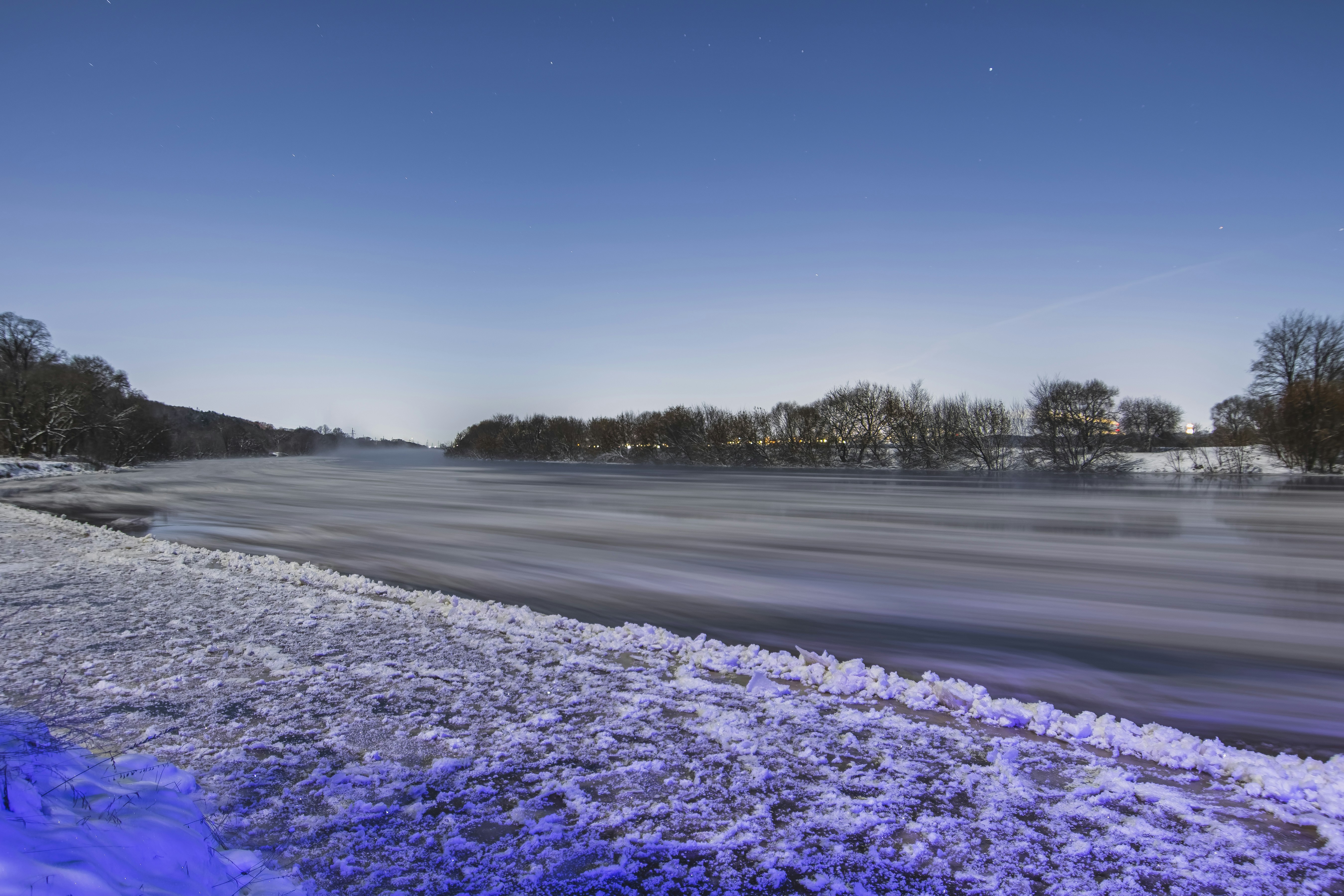 Blue Hour on a Frozen River: Snow-Covered Banks and Silky Water