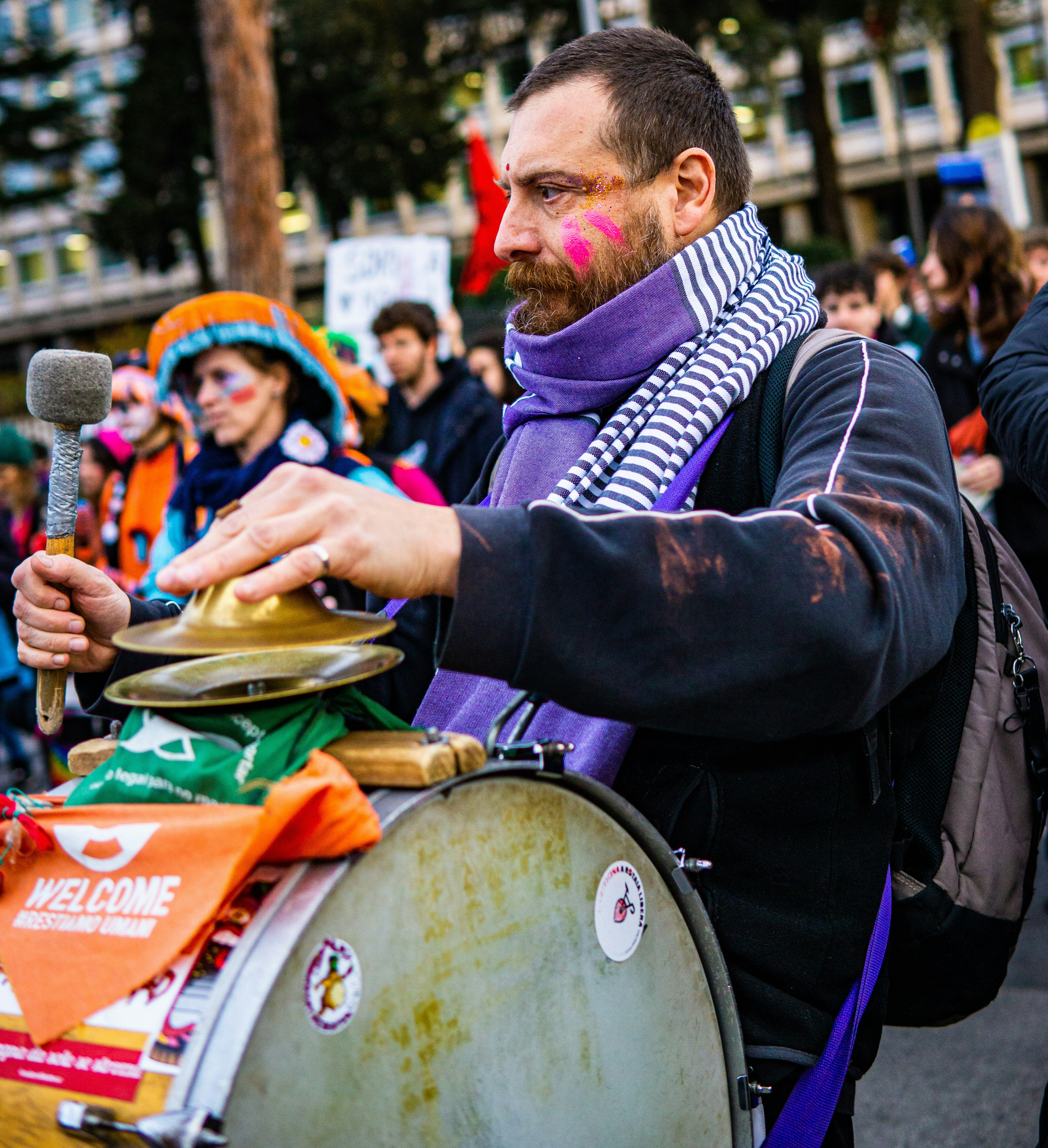 A man holding a large metal drum in front of a group of people photo ...