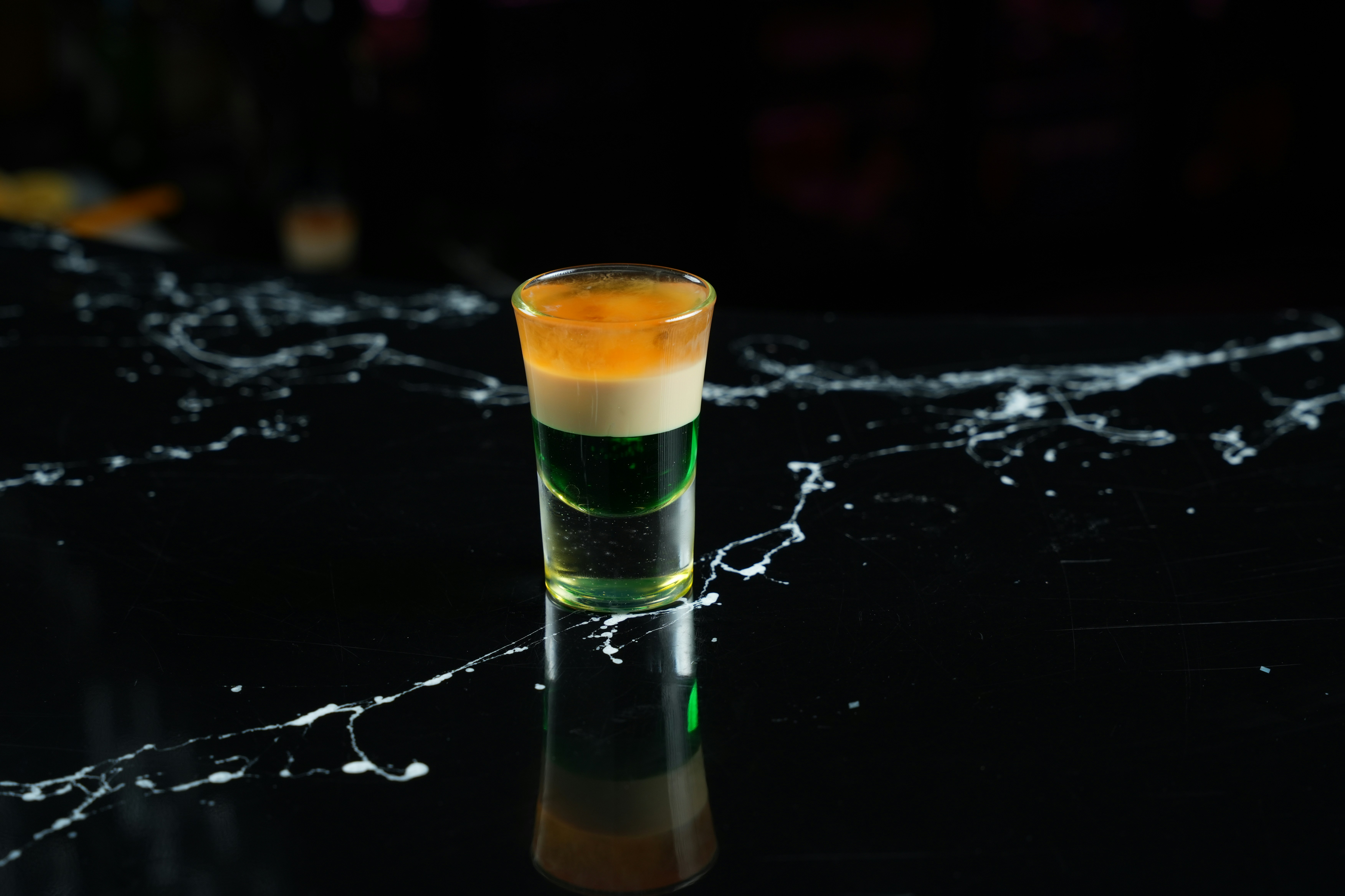 A shot glass filled with liquid sitting on top of a counter photo ...