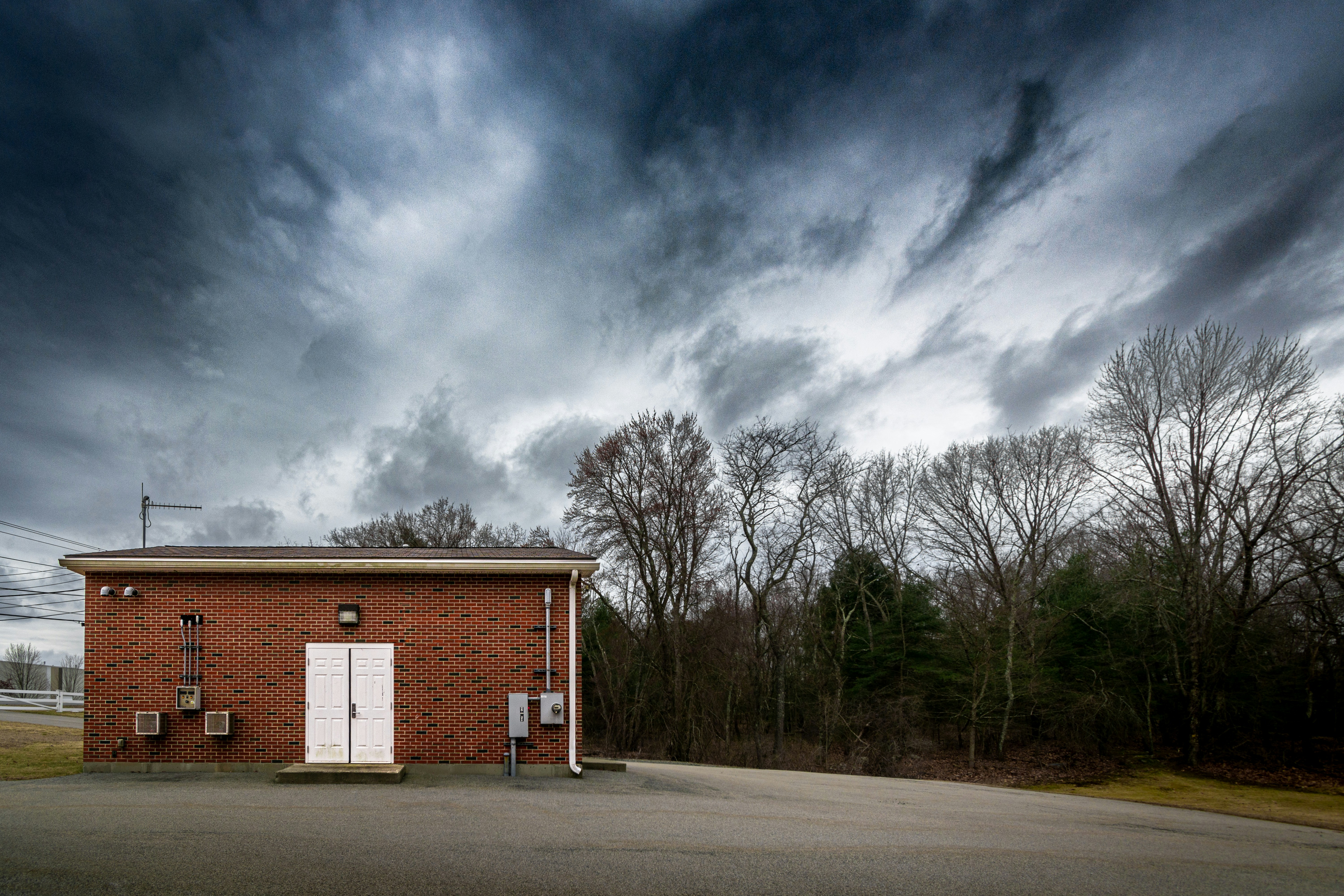 Silent Sentinel: The Brick Structure Beneath Stormy Skies