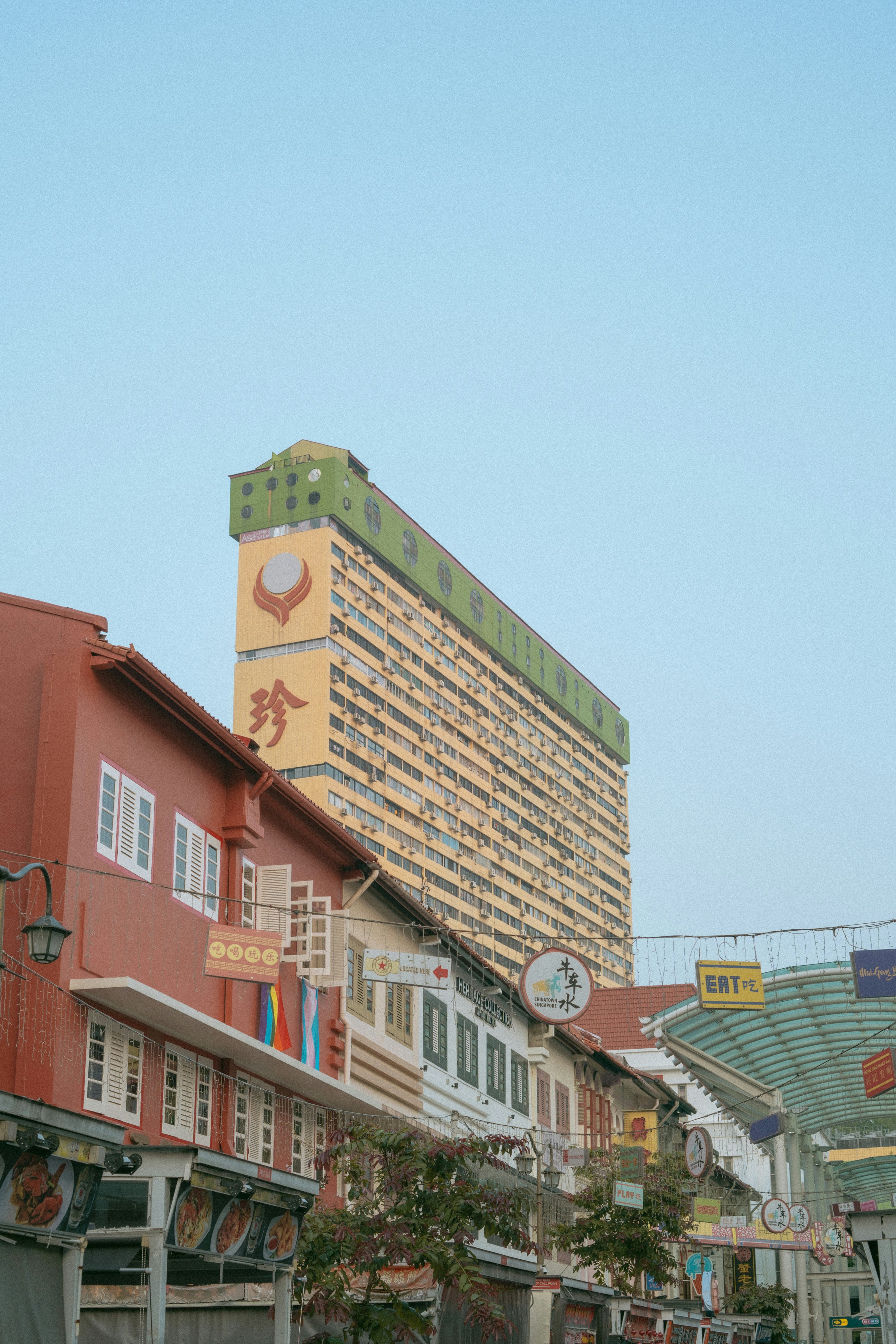 Green-Topped Tower Over a Colorful Shophouse Row