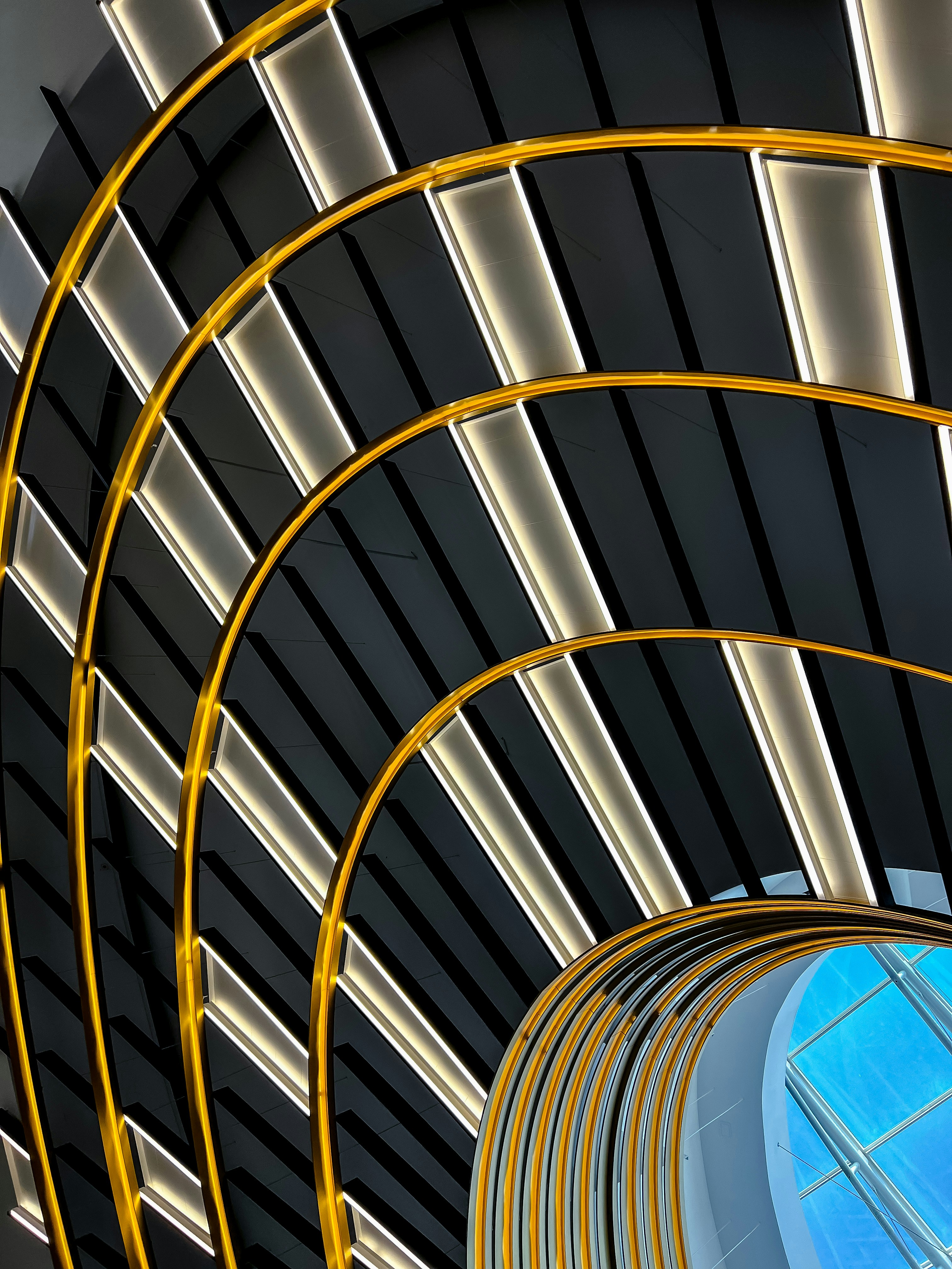 Concentric Neon Rings Spiral Through a Glass Atrium