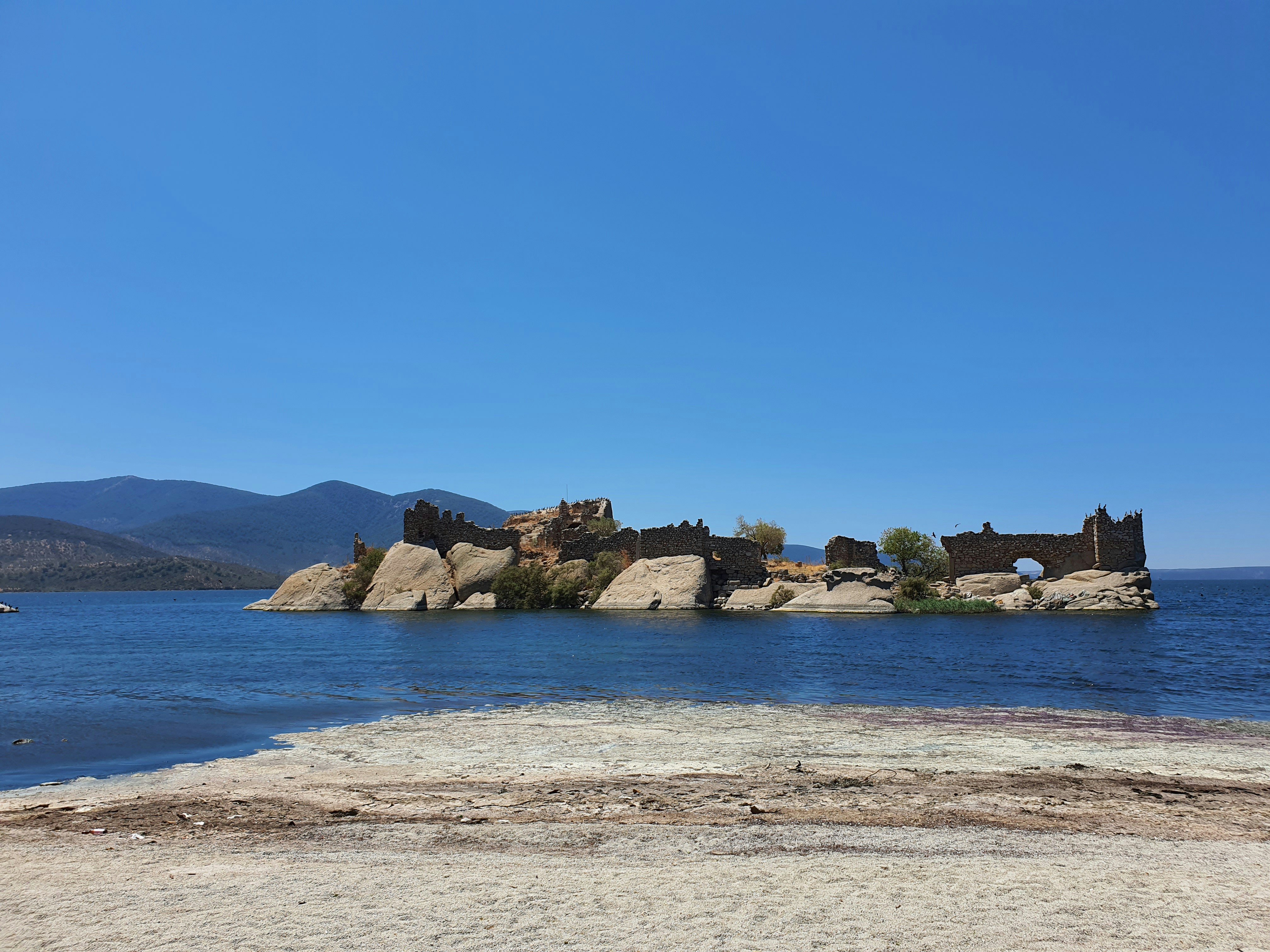 Ruins on a Seaside Isle Beneath a Clear Azure Sky