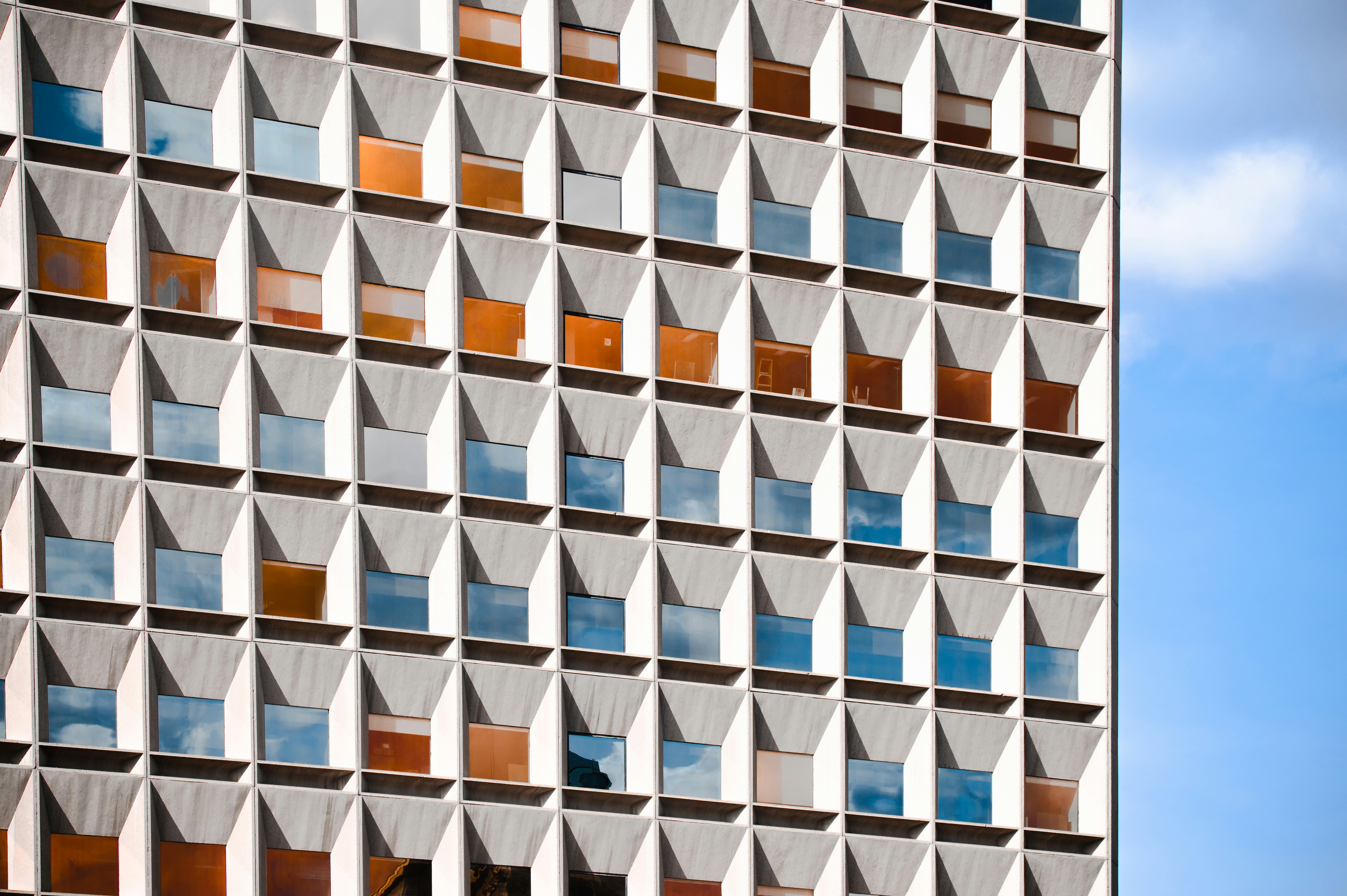 A tall building with lots of windows and a sky background photo – Free ...