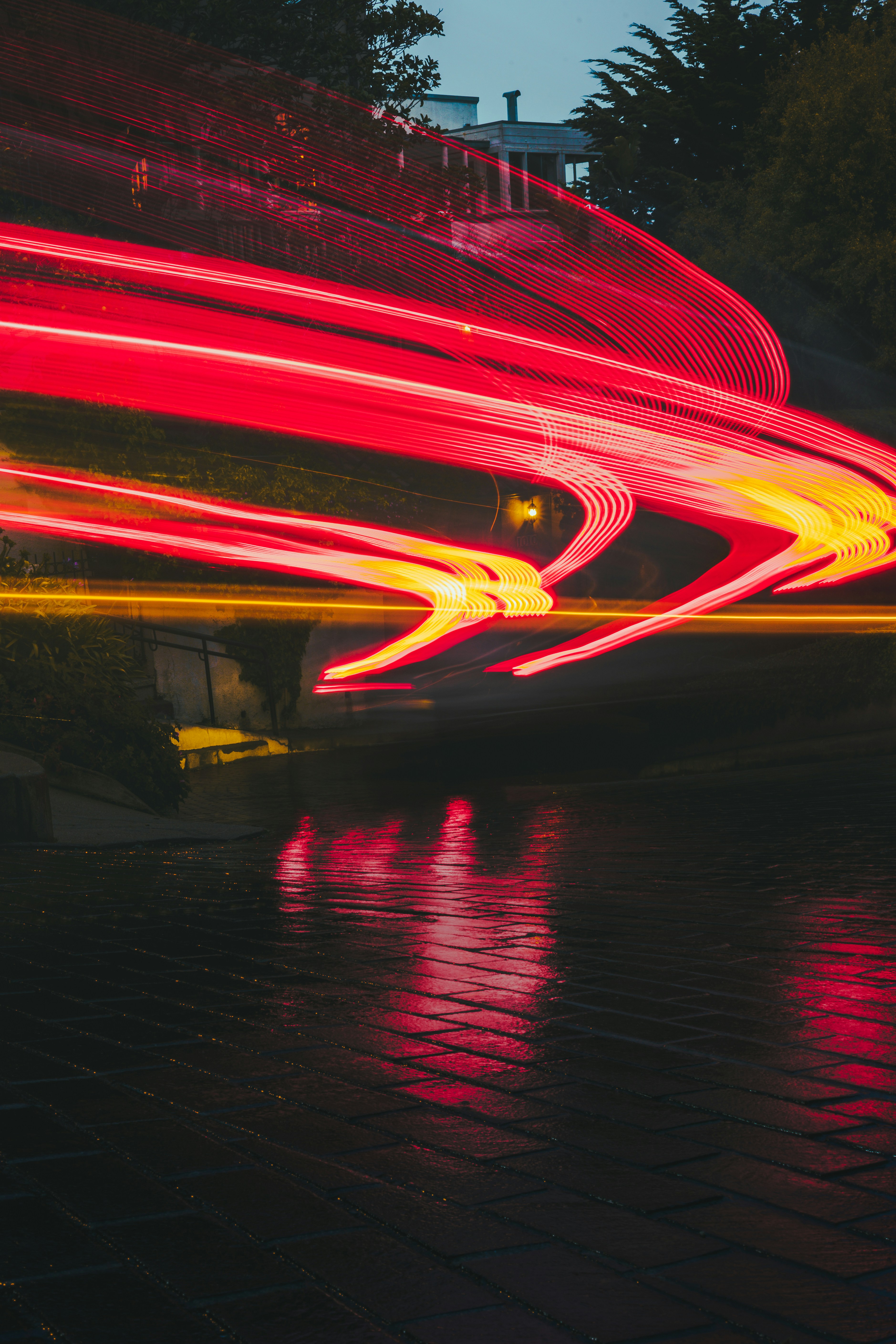 Red Night Arcs: Long-exposure Light Trails on a Wet Street