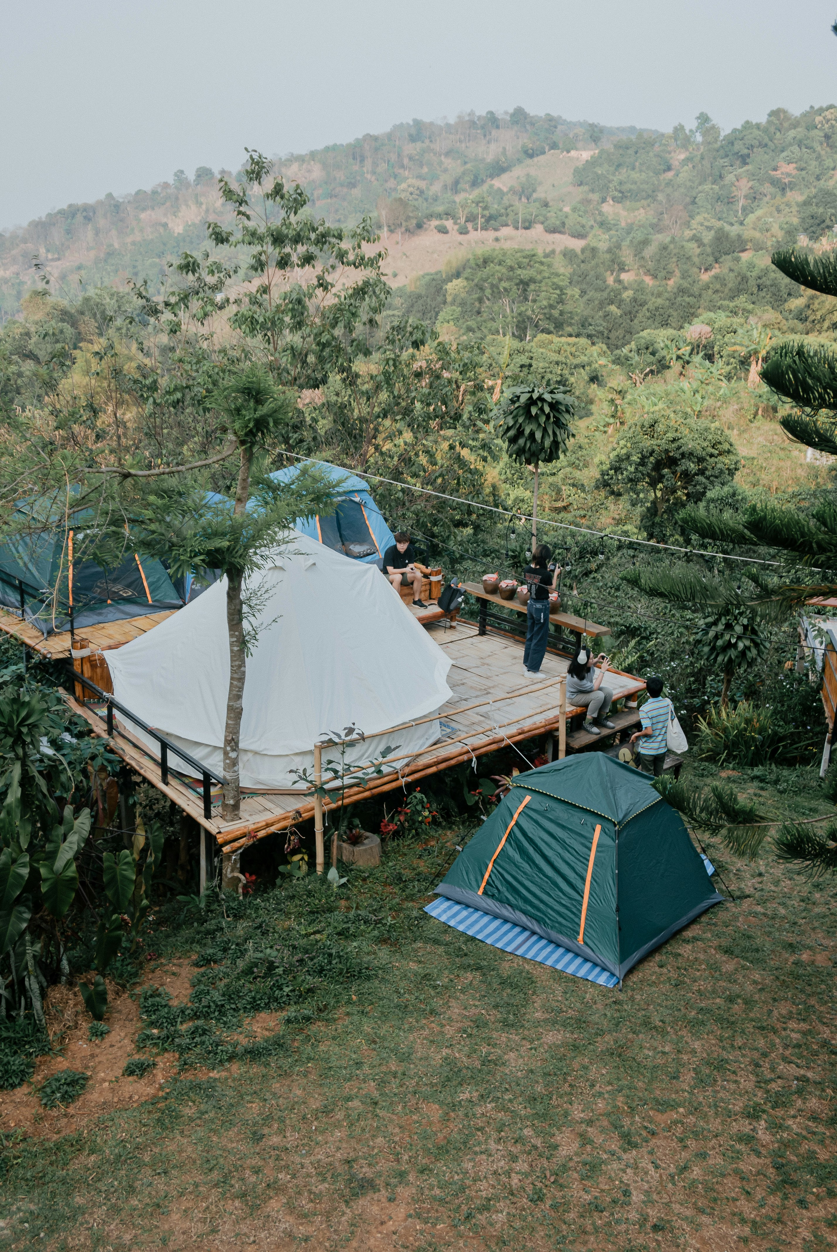 Camping on a mountain top | a couple of tents sitting on top of a lush green hillside