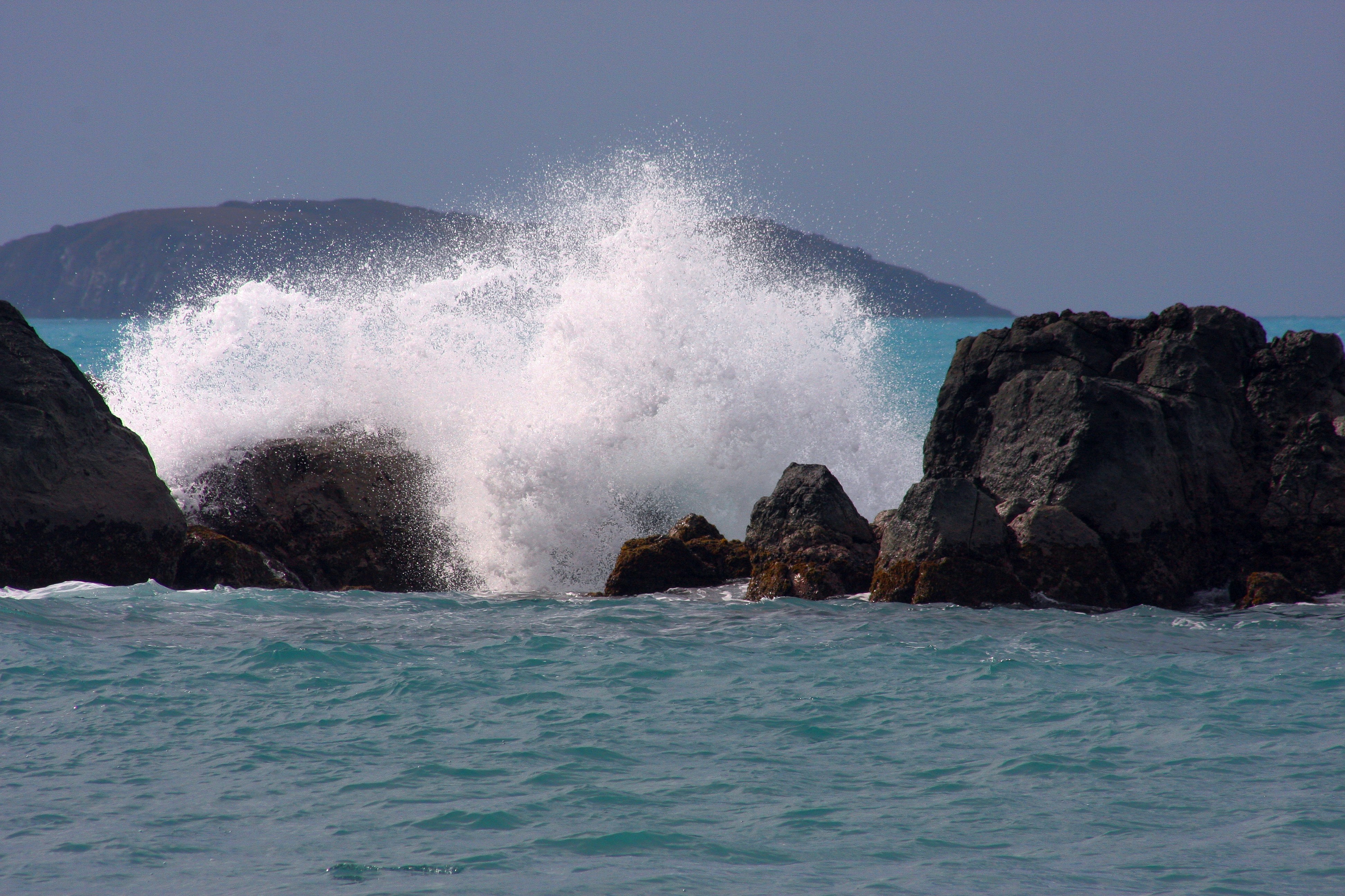 A large wave crashes into the rocks in the ocean photo – Free St ...