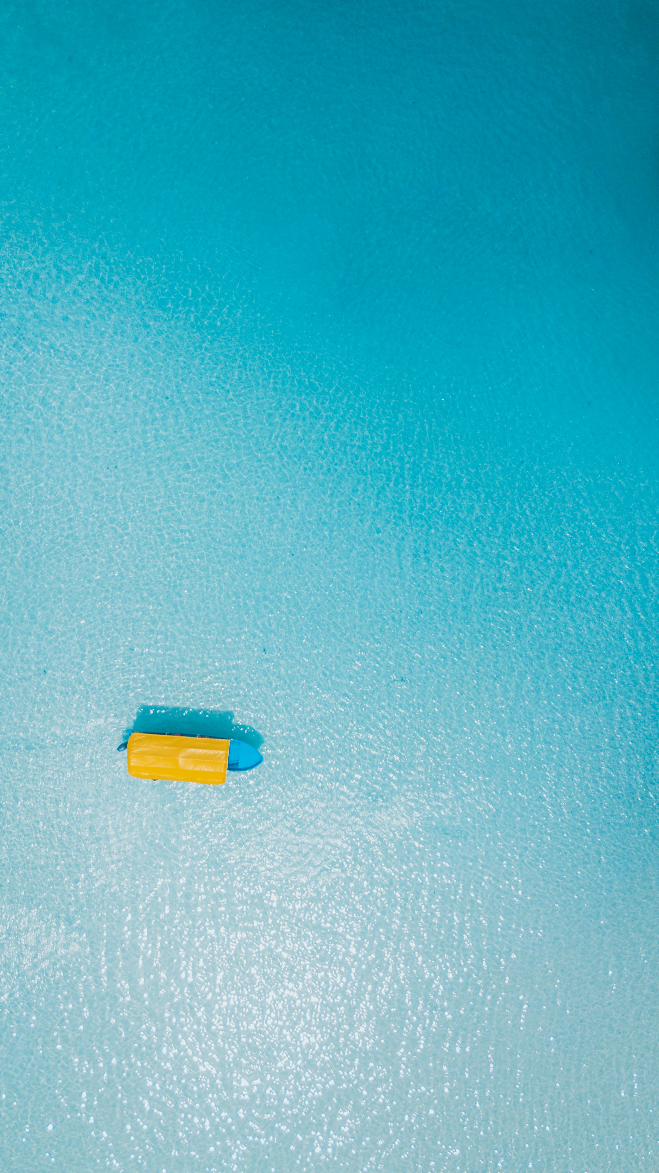 A yellow and blue object floating in the water photo – Free Boat on ...