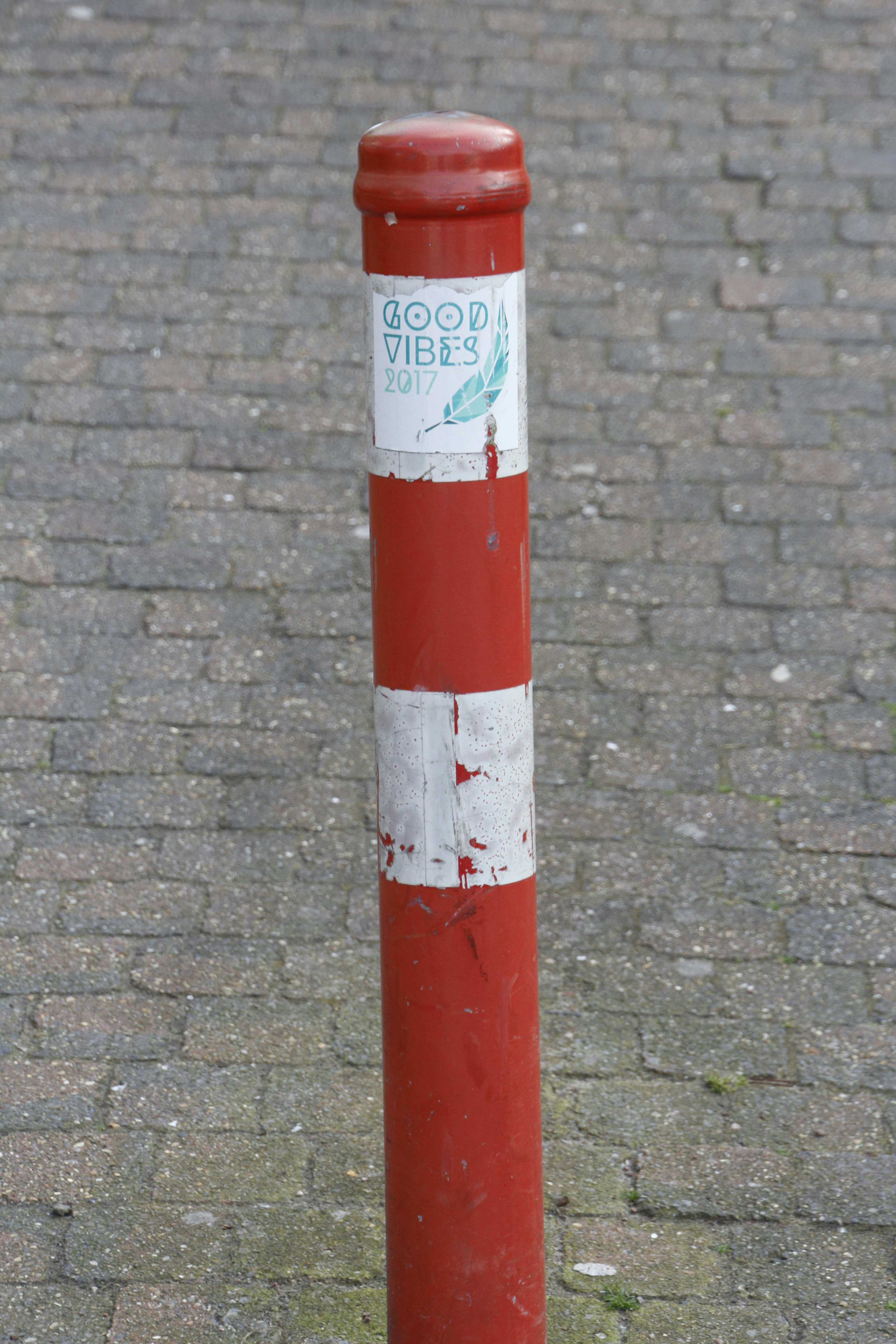 A red and white pole with a good vibes sticker on it photo – Free ...