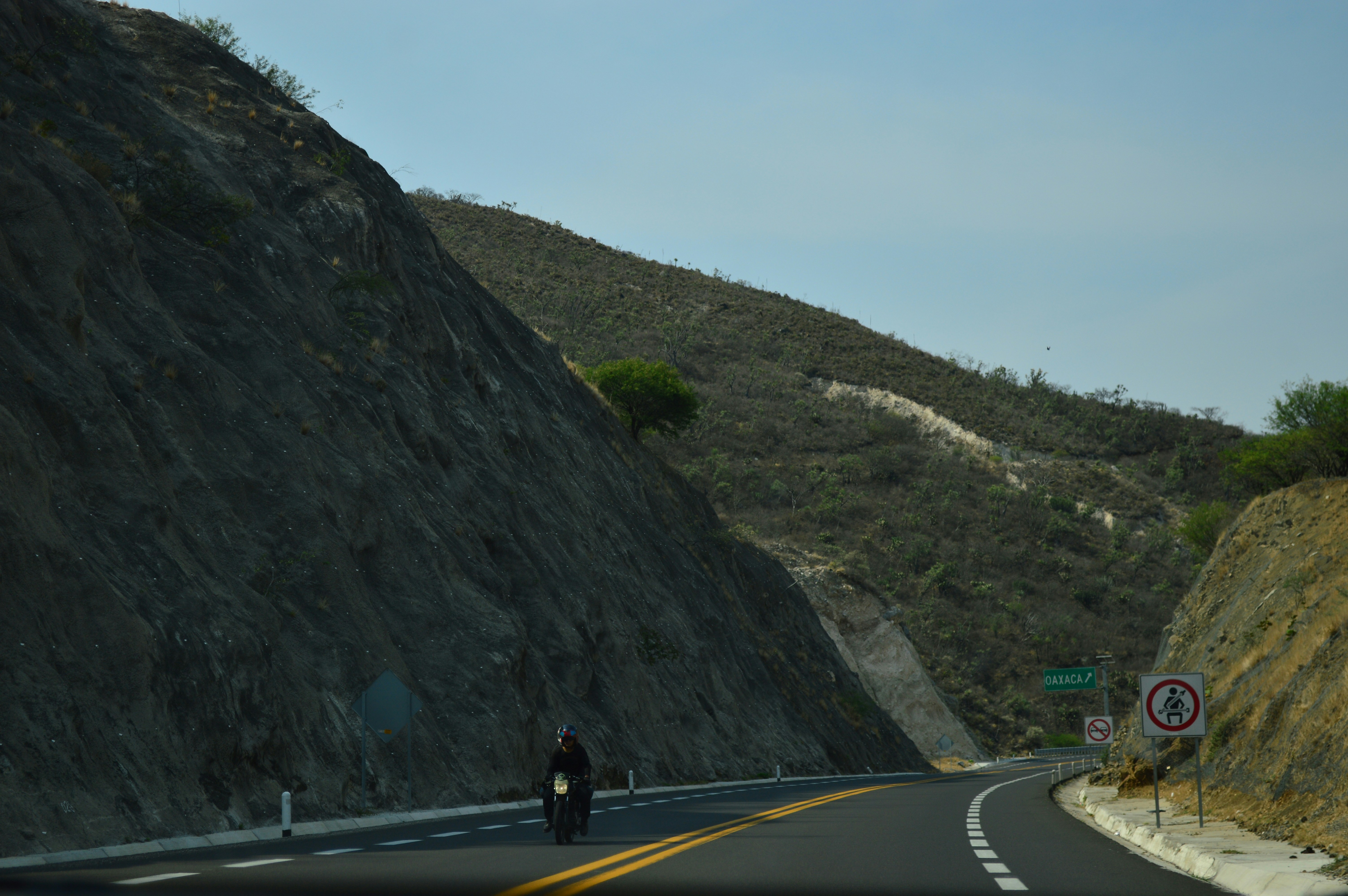 Serpentine Mountain Pass: A lone rider threads a sunlit curve