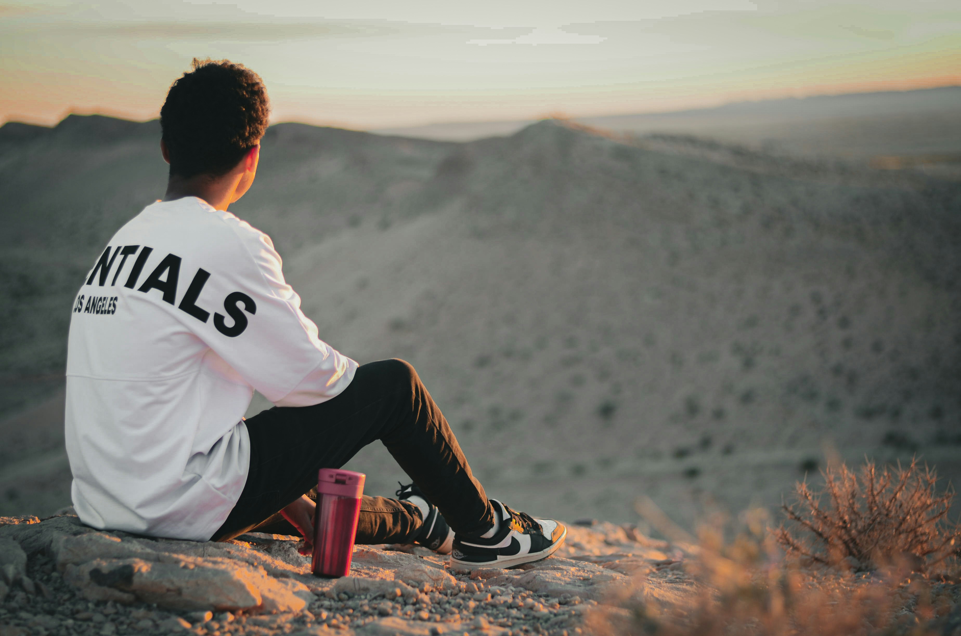 Horizon Quiet: A Figure Resting on Desert Outcrop at Sunset