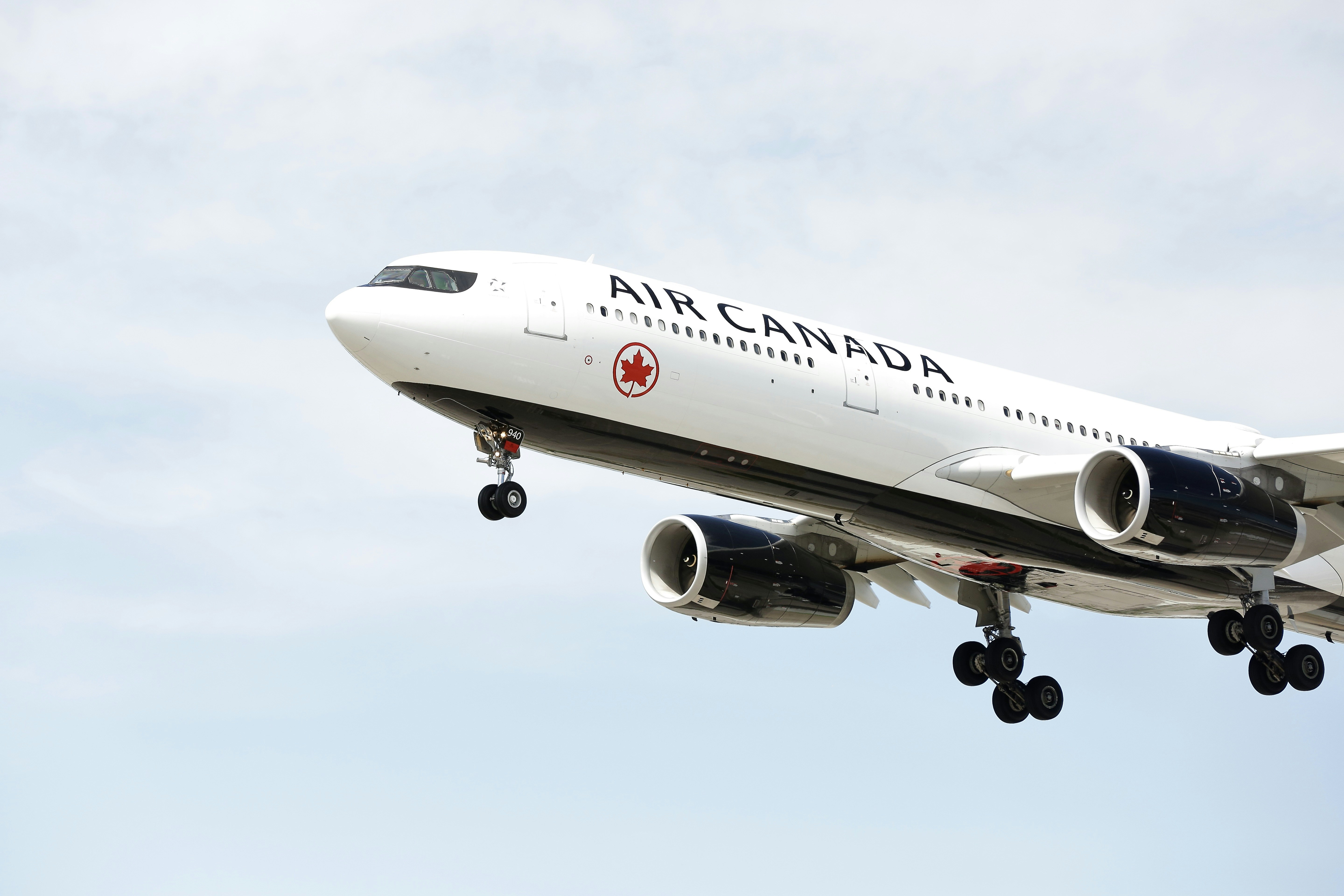 A large air canada jet flying through a blue sky photo – Free Aircraft ...