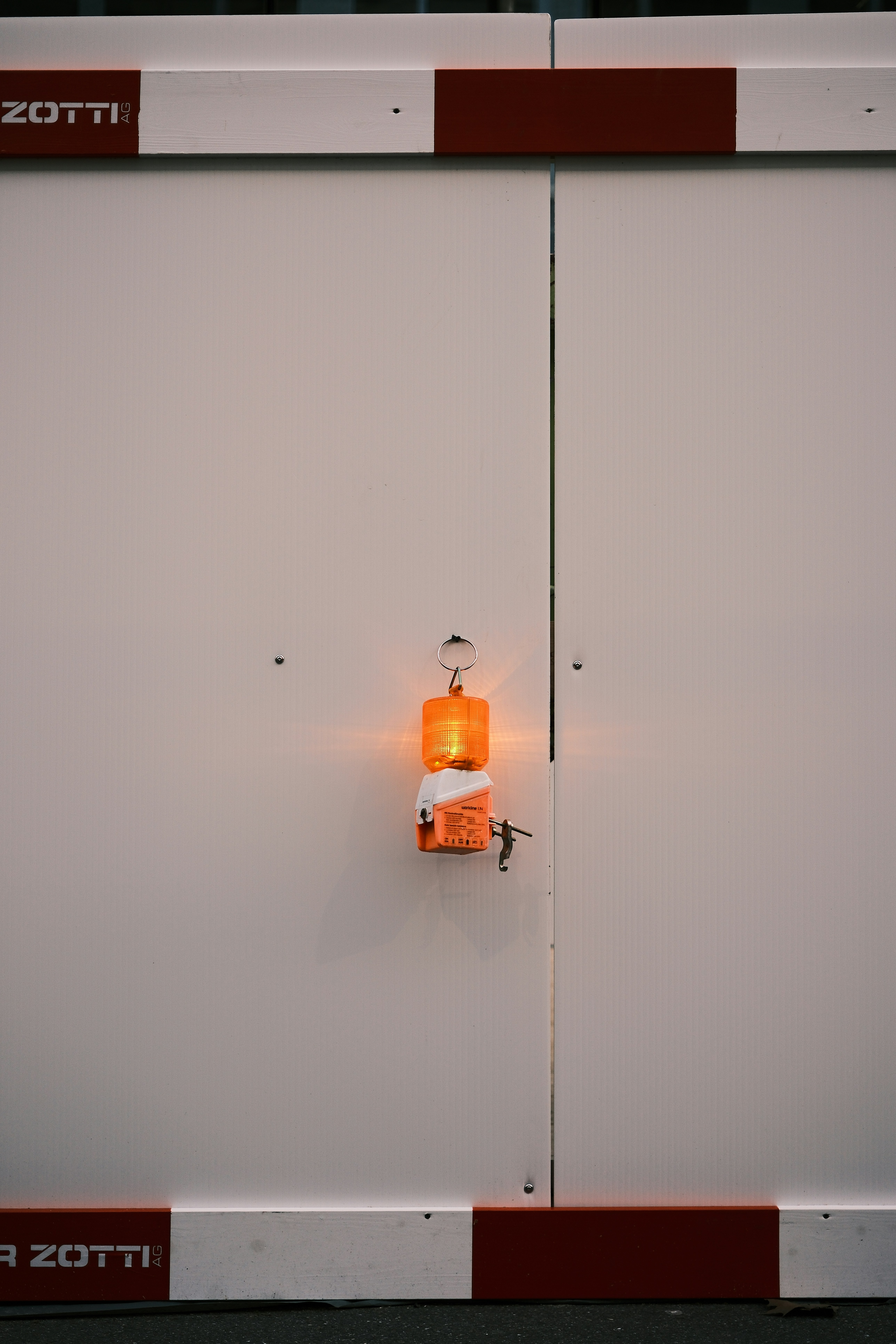 Orange Warning Beacon Anchored to a Quiet Barrier