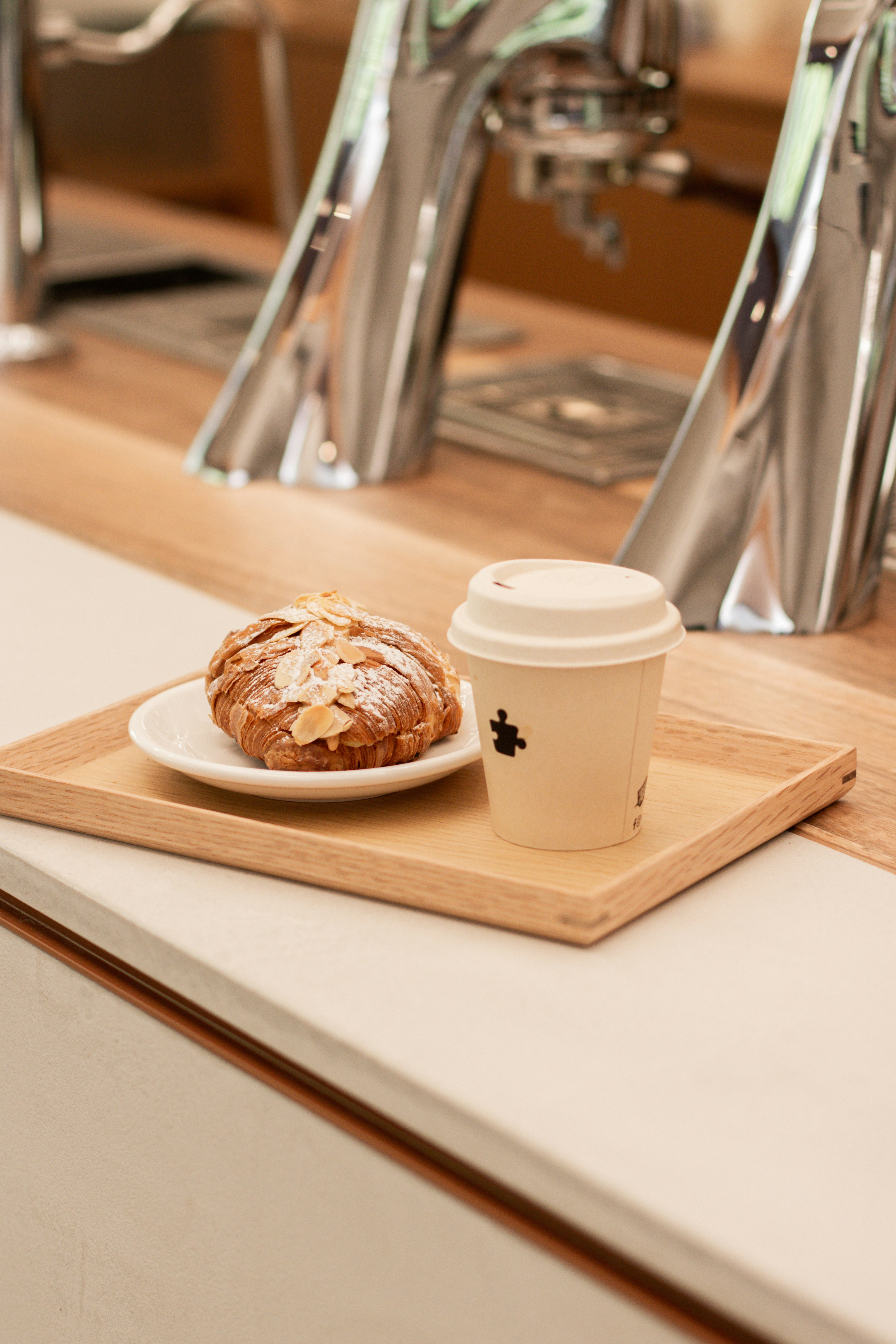 Amber Croissant and Takeaway Coffee on a Wooden Cafe Counter