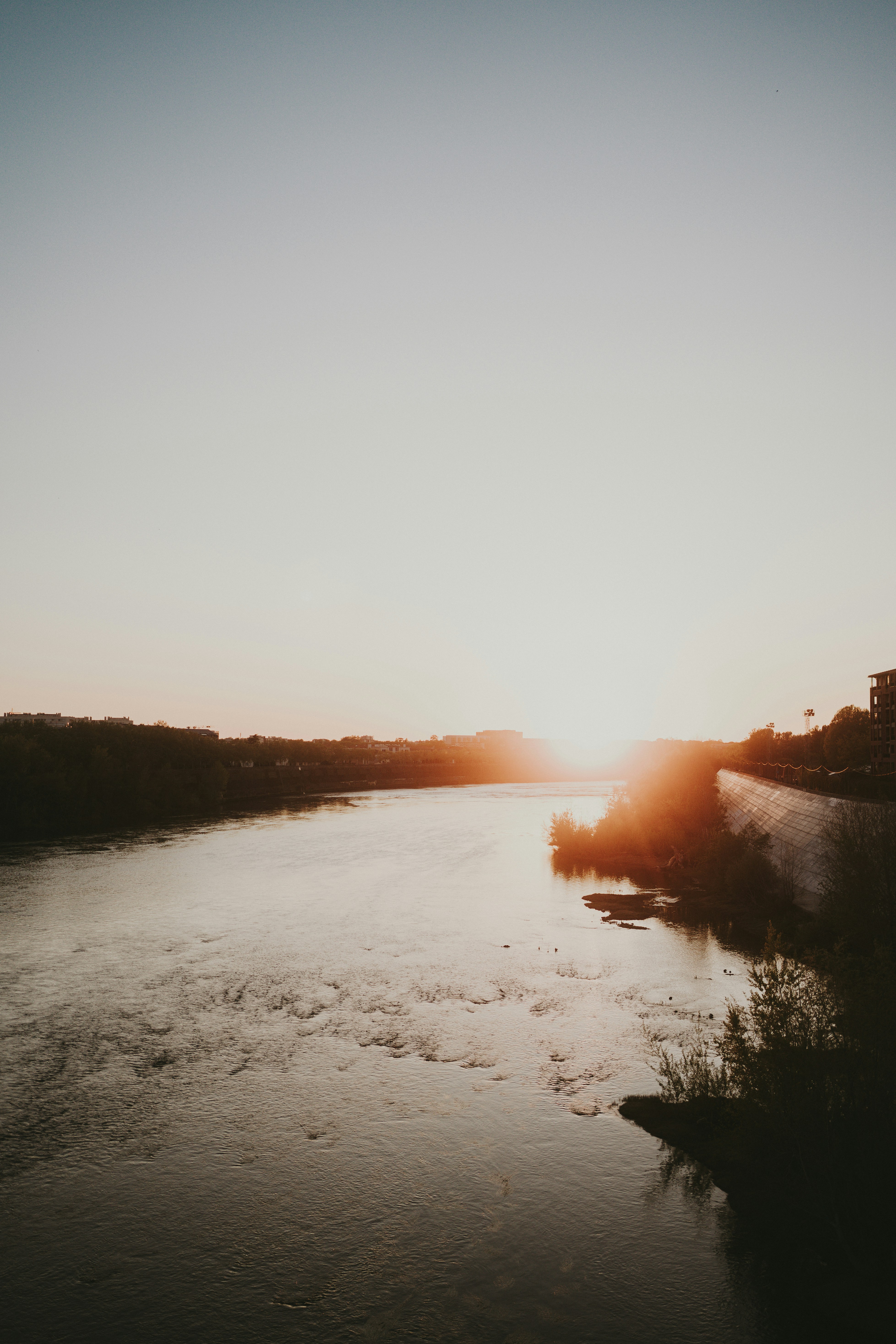 Foto El sol se está poniendo sobre un río en medio del día – Imagen ...