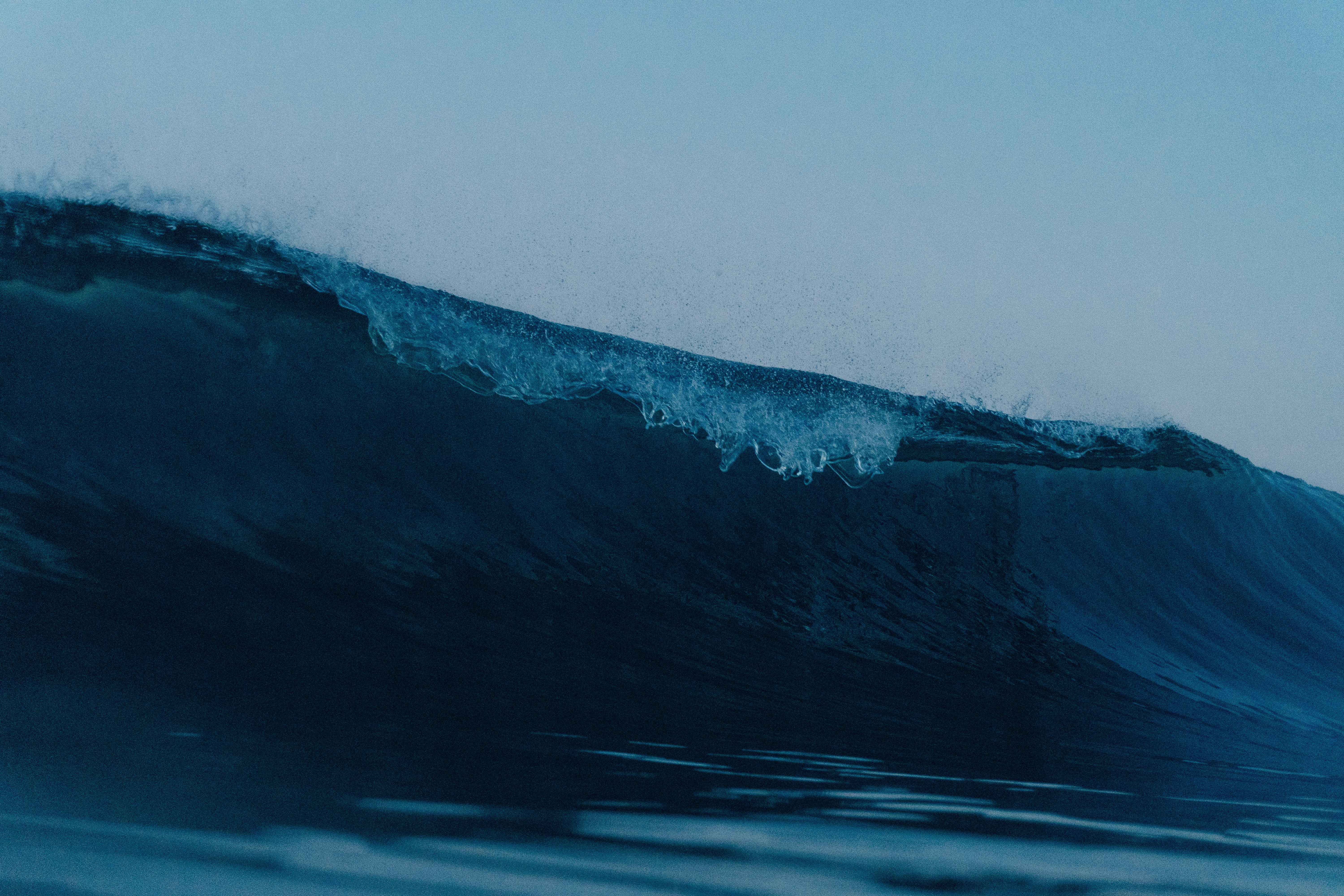 Cobalt Crest: a curling blue wave captured in quiet blue light
