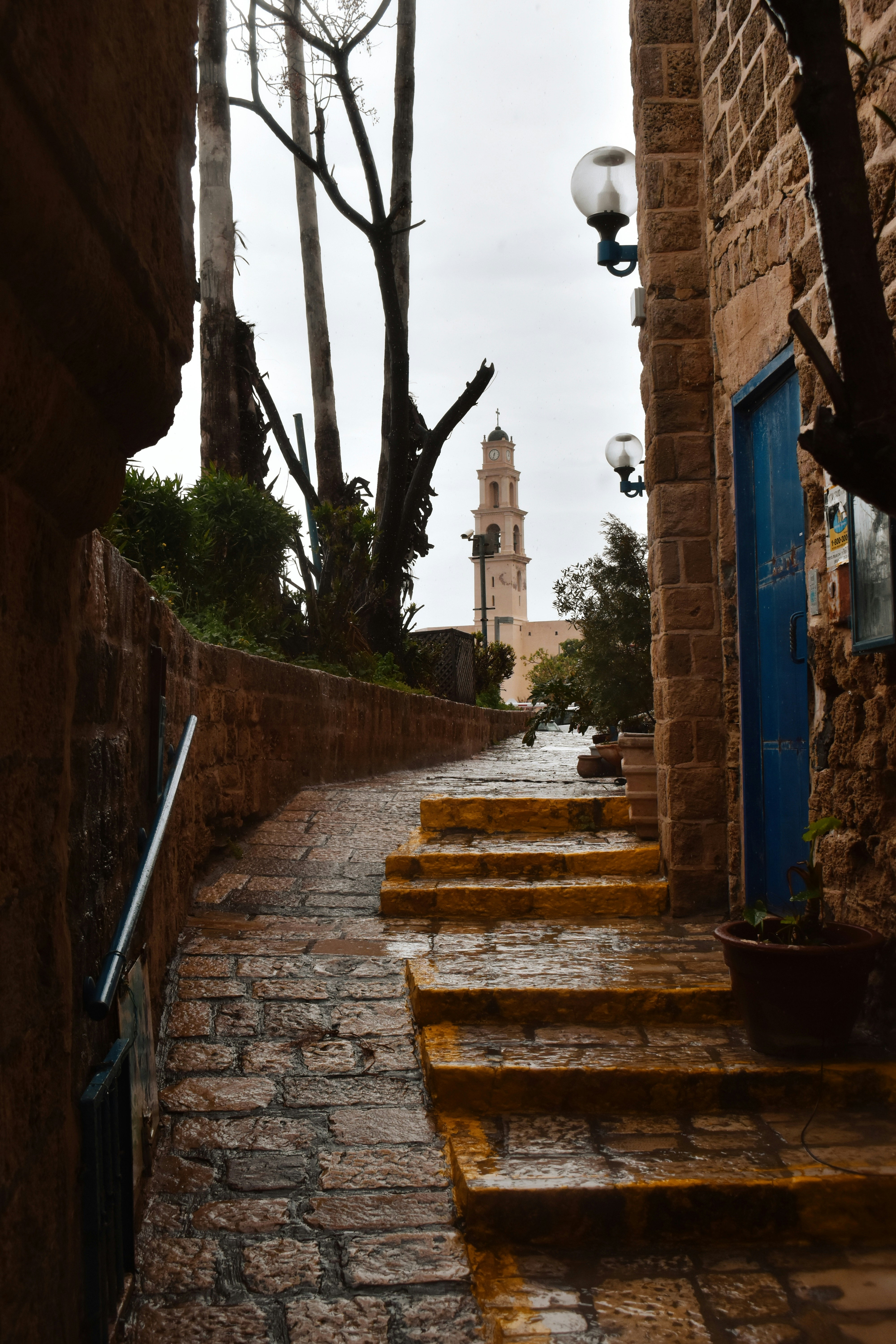 A cobblestone street with steps leading up to a clock tower photo ...