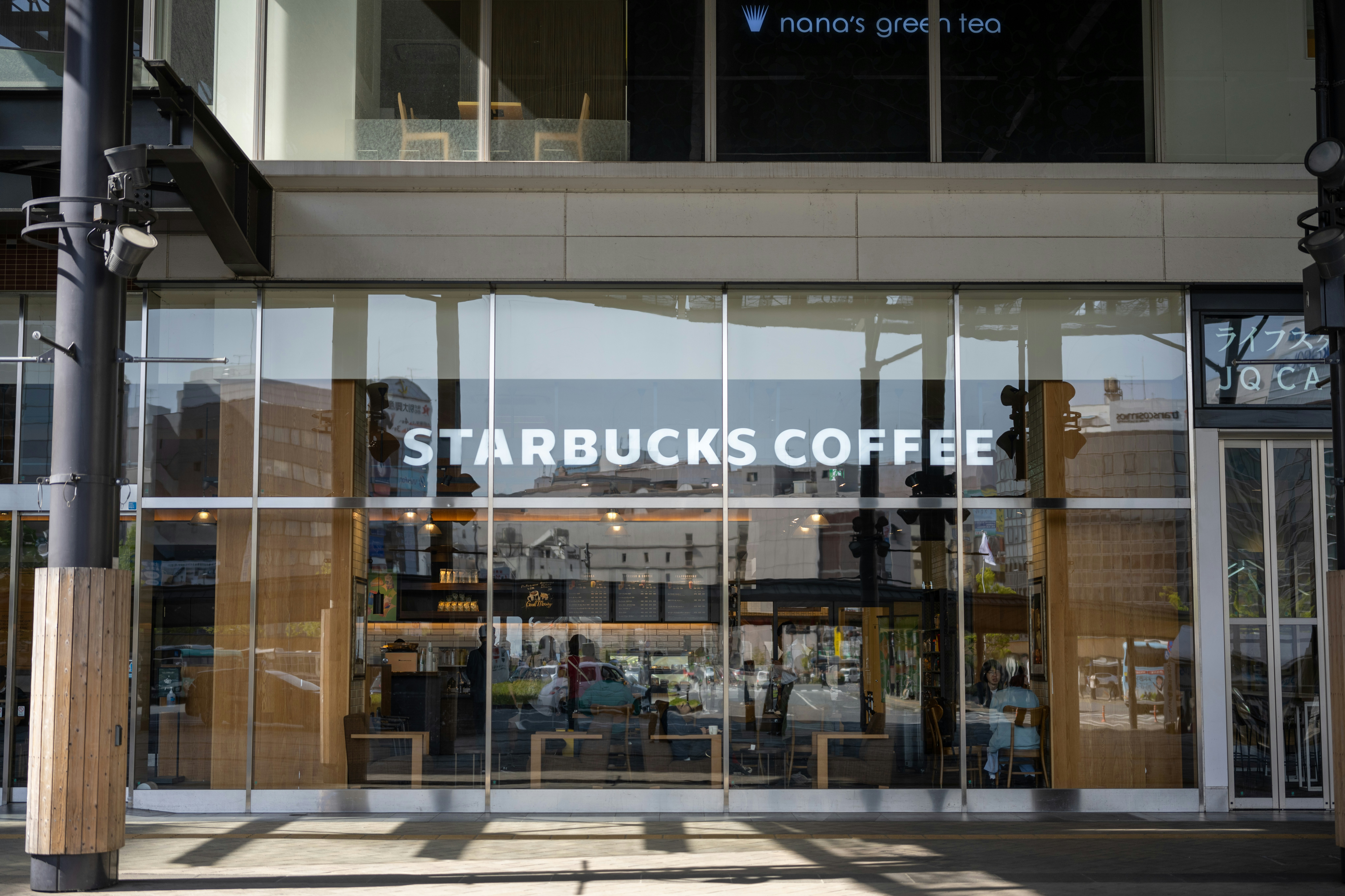 A starbucks coffee shop on the corner of a street photo – Free Door ...