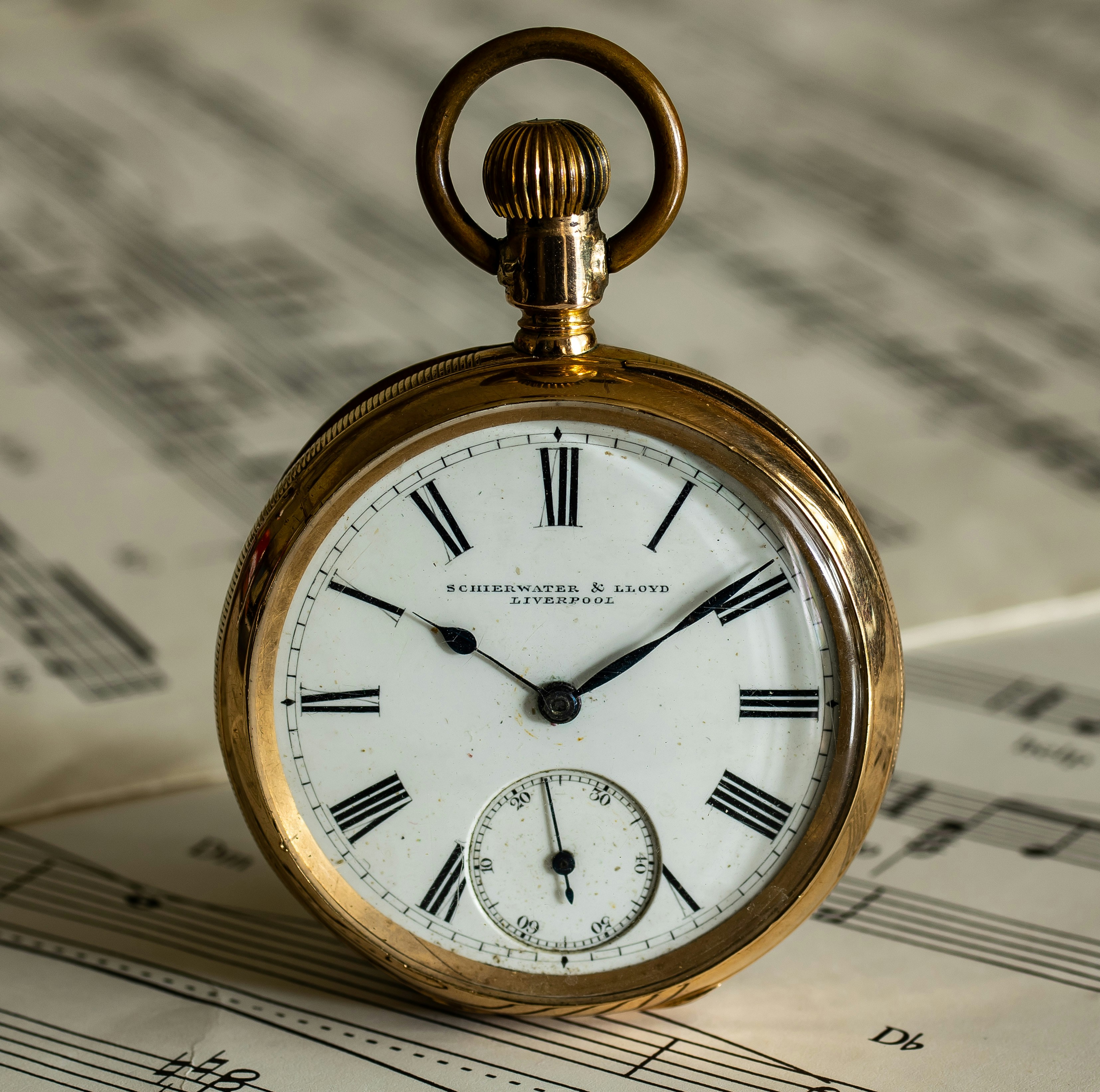 A pocket watch sitting on top of sheet music photo – Free Music Image ...