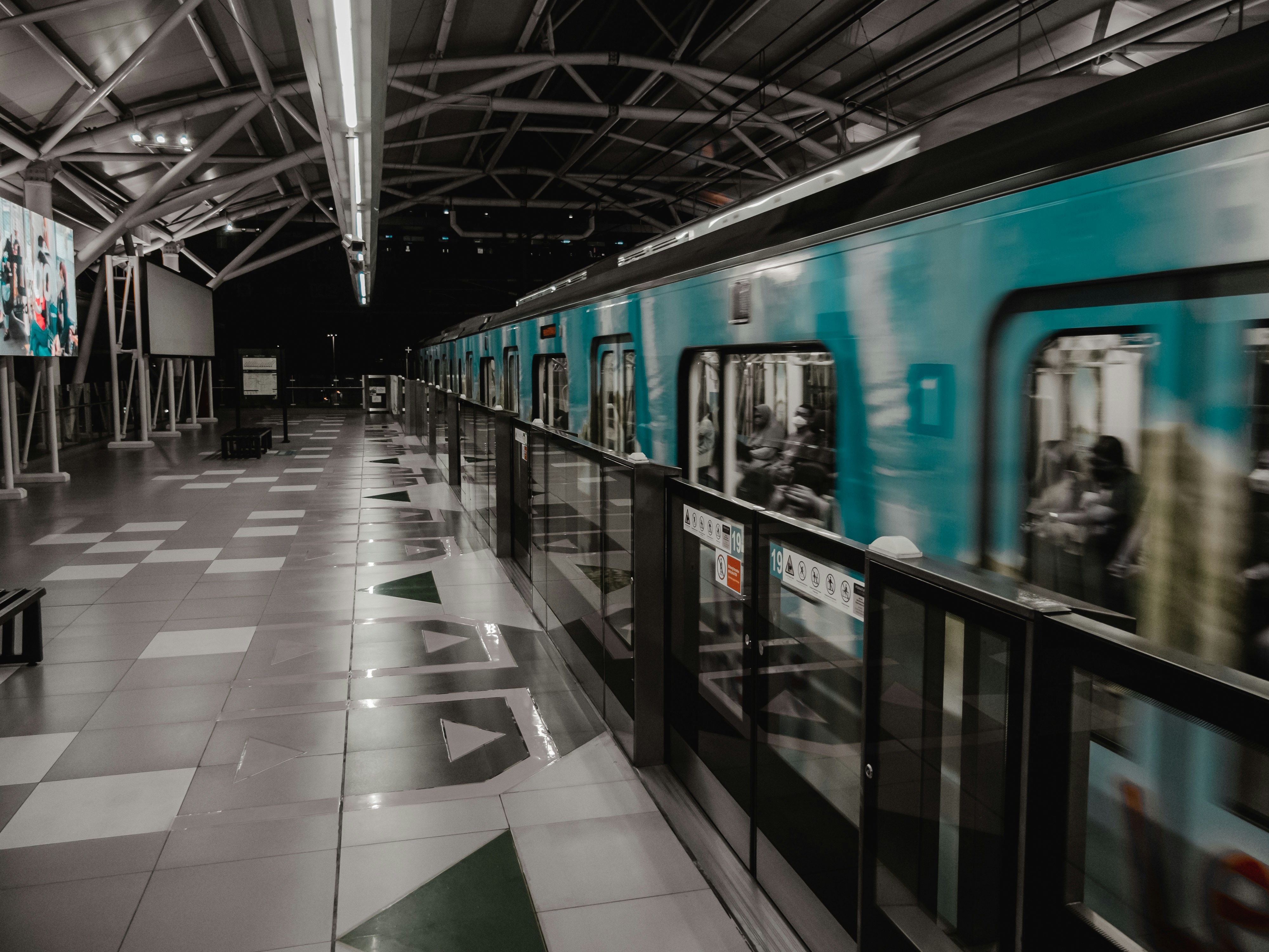A train traveling through a train station next to a platform photo ...