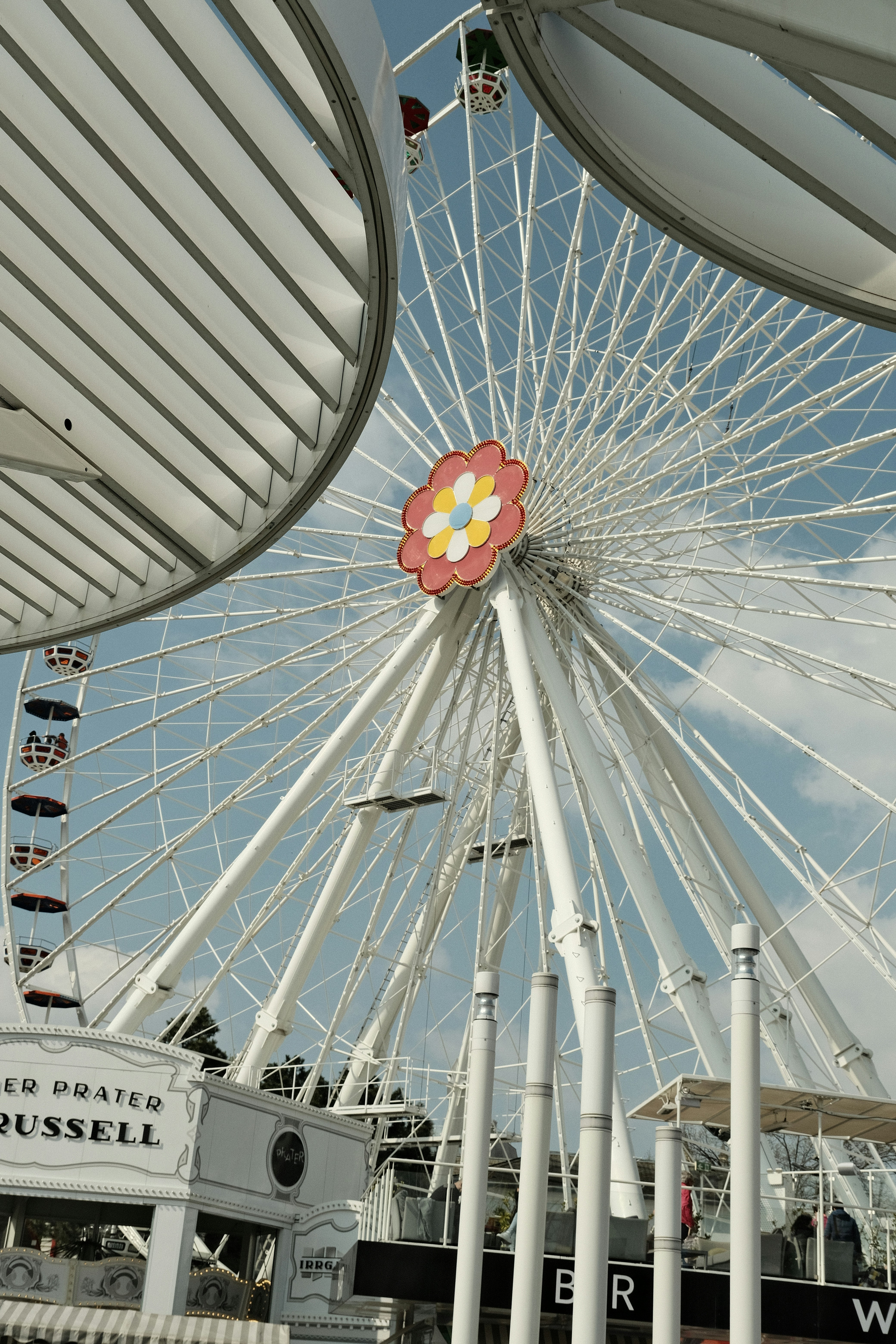 Floral hub of a towering Ferris wheel under a cobalt sky