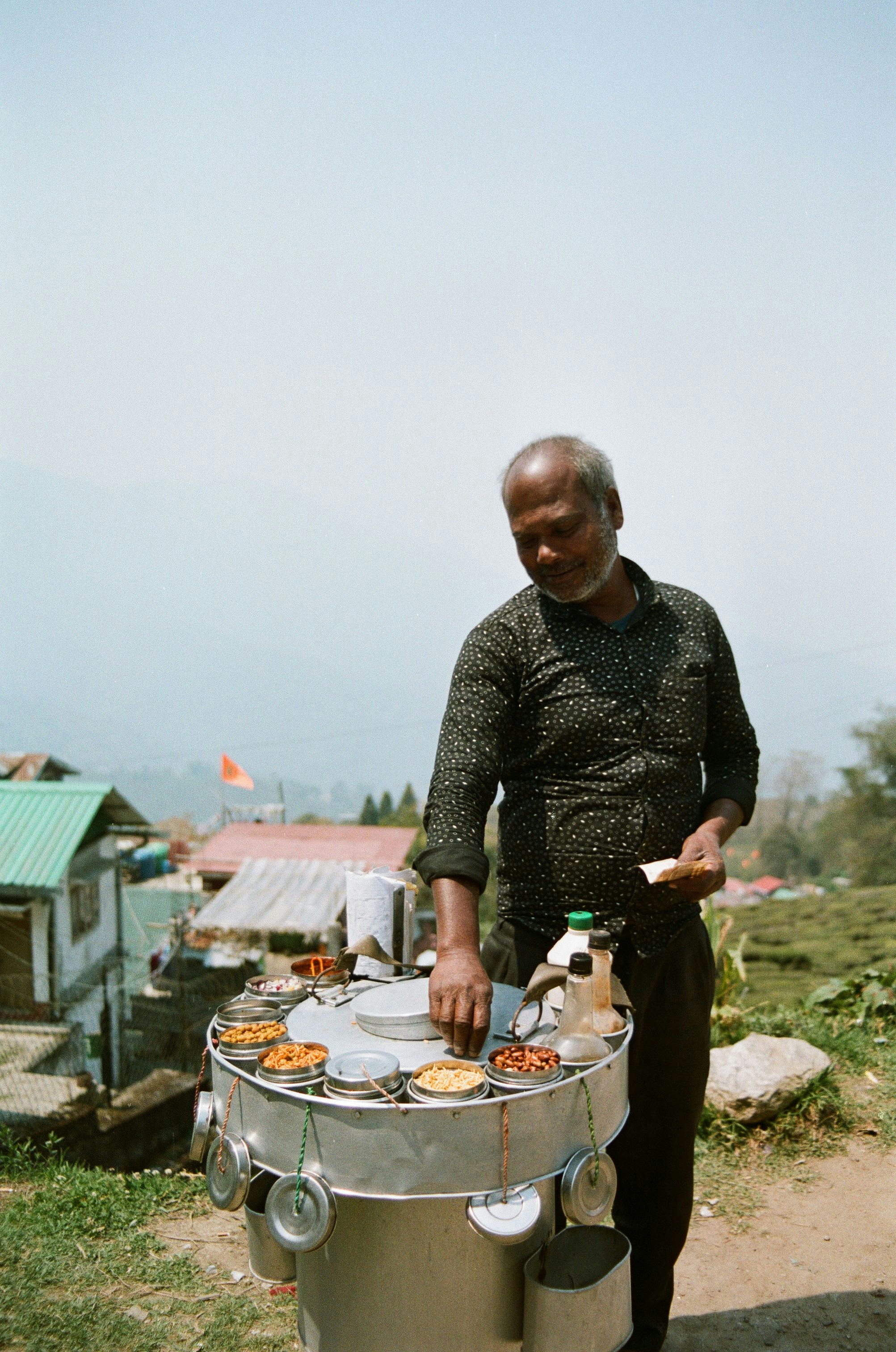 A man standing next to a large pot filled with food photo – Free Food ...