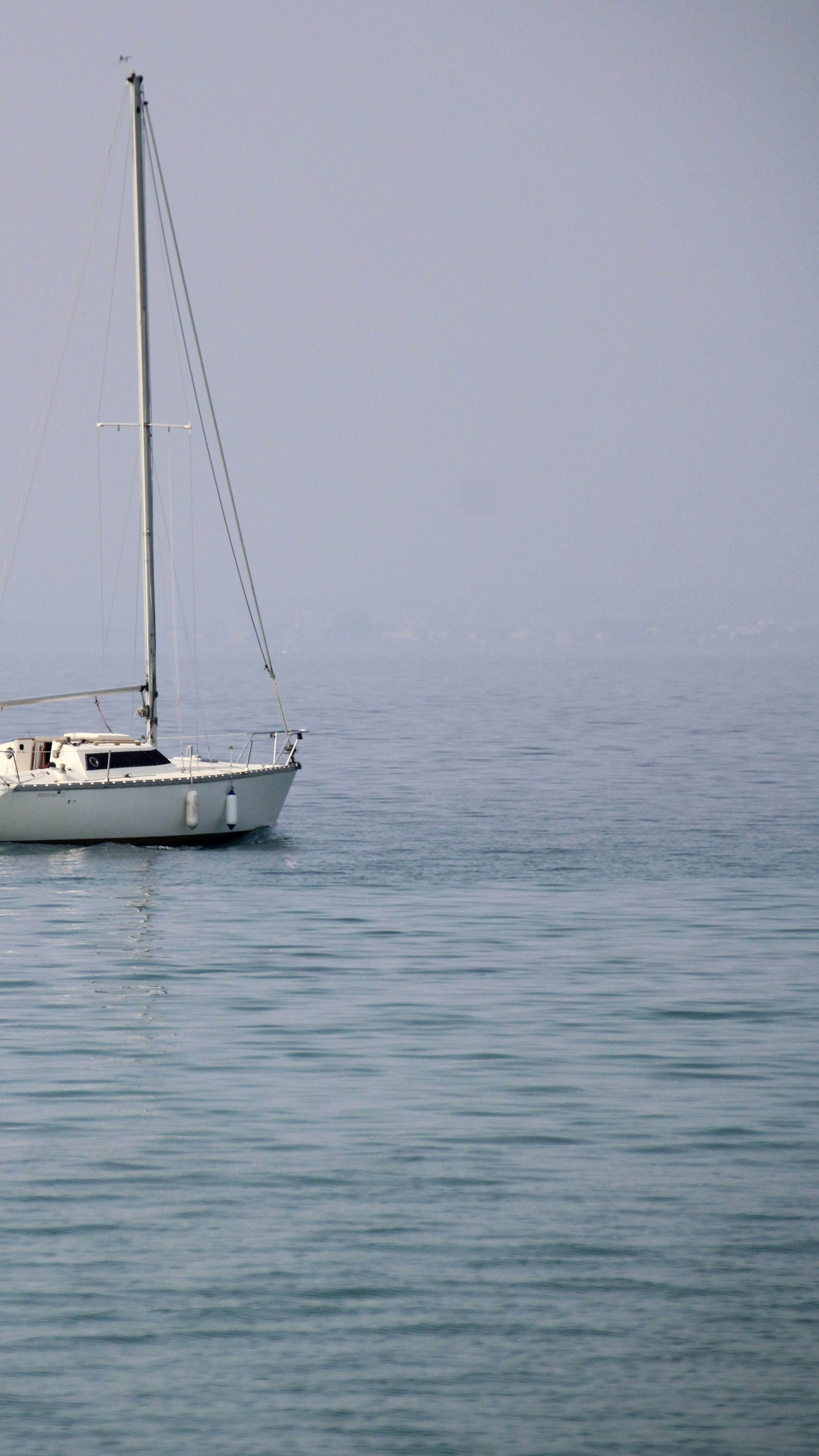 A sailboat floating in the ocean on a foggy day photo – Free Italia ...