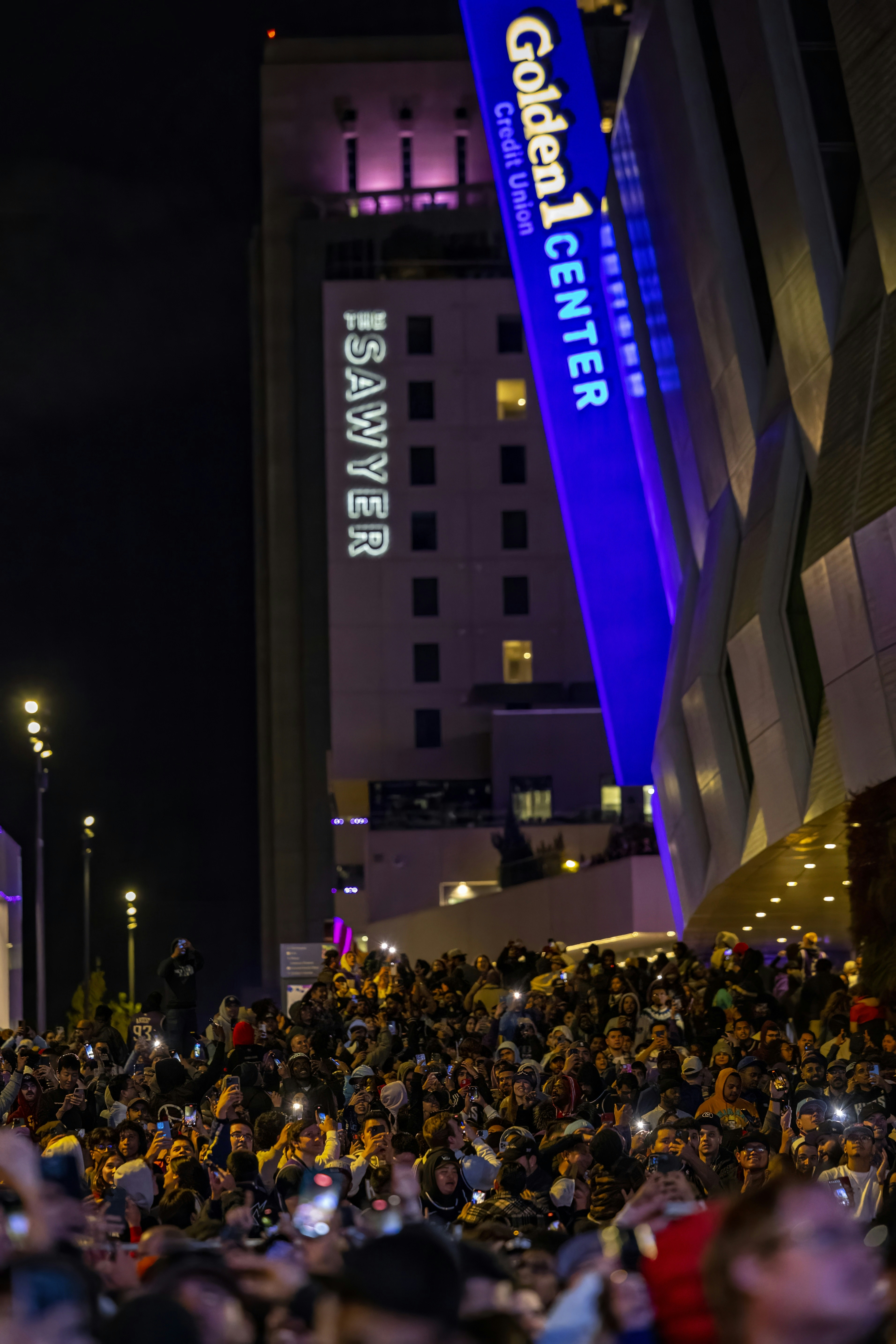 A crowd of people standing around a tall building photo – Free City ...