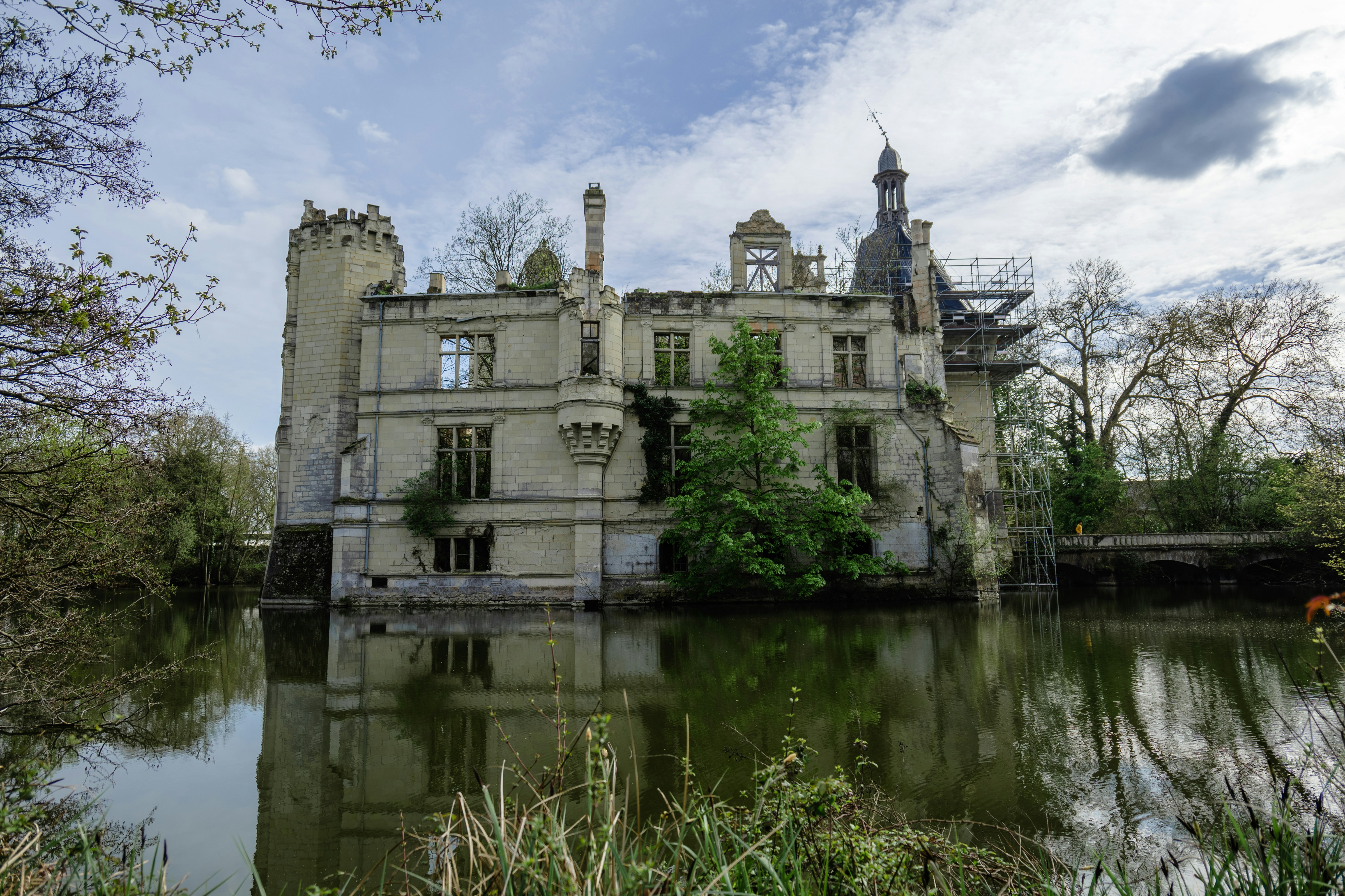 Waterbound Ruin: A Moat-encircled Castle Reaches Skyward Amid Reflections