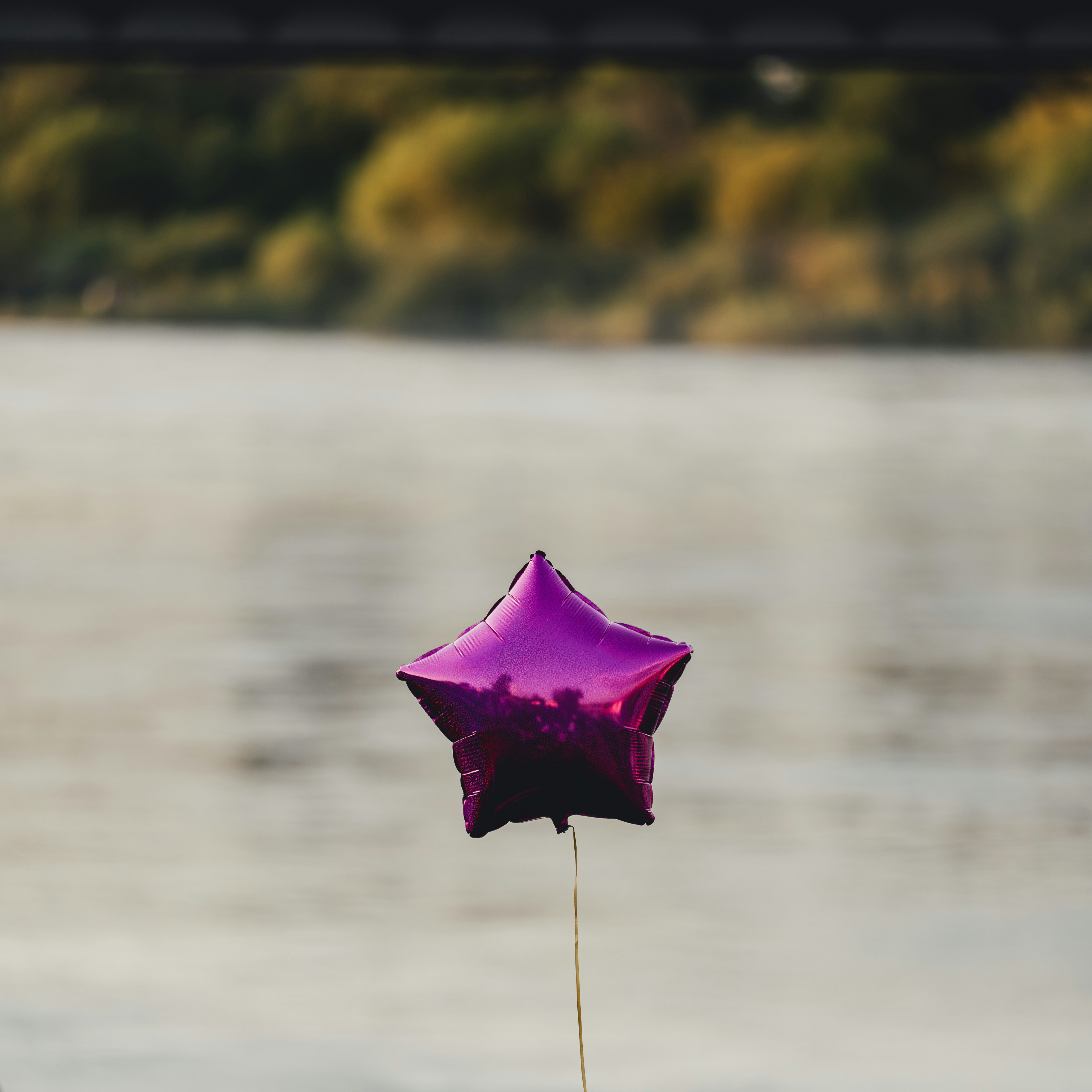 Purple Star Balloon Adrift Over Quiet Water
