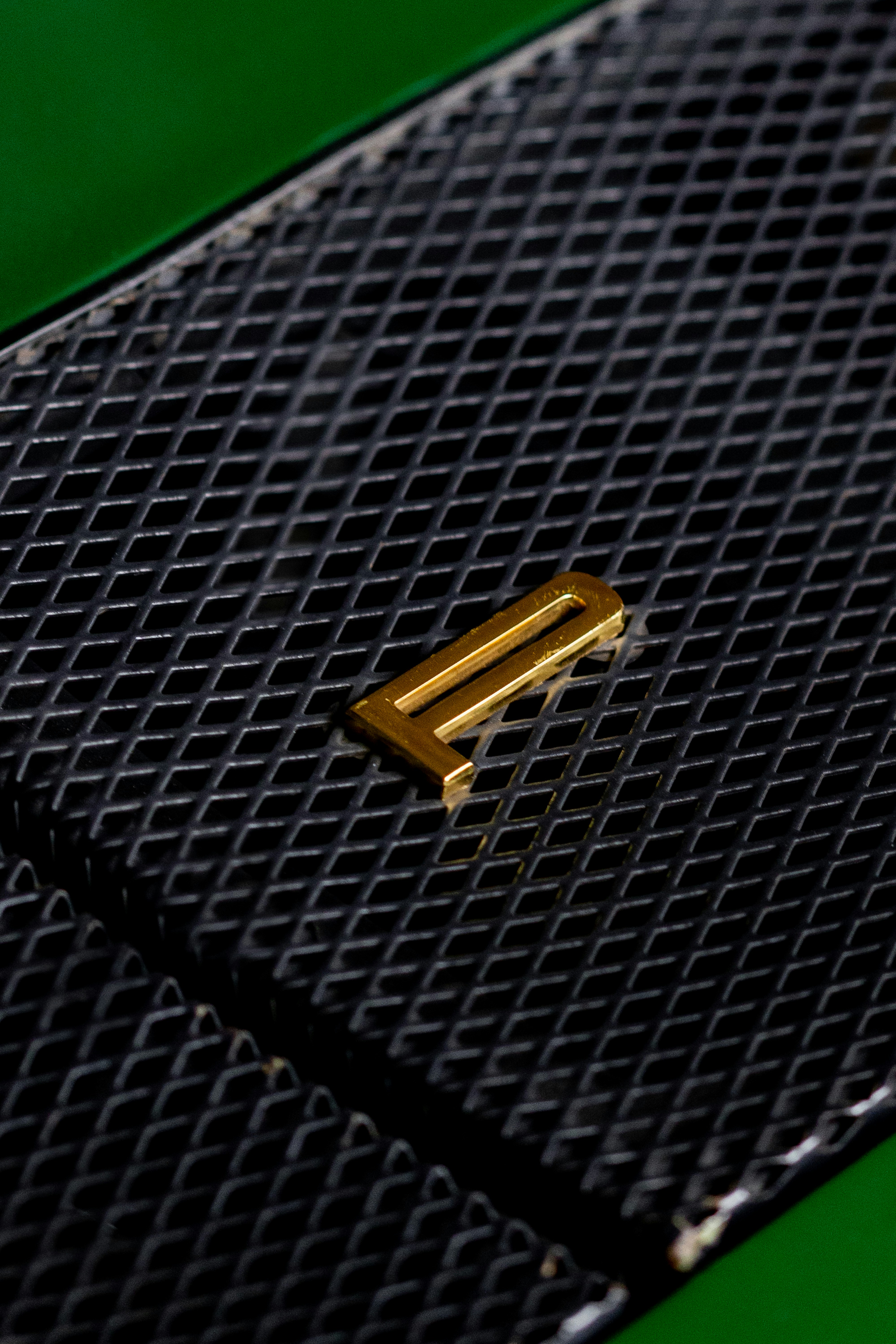 Lone brass numeral on a perforated grid with a green edge