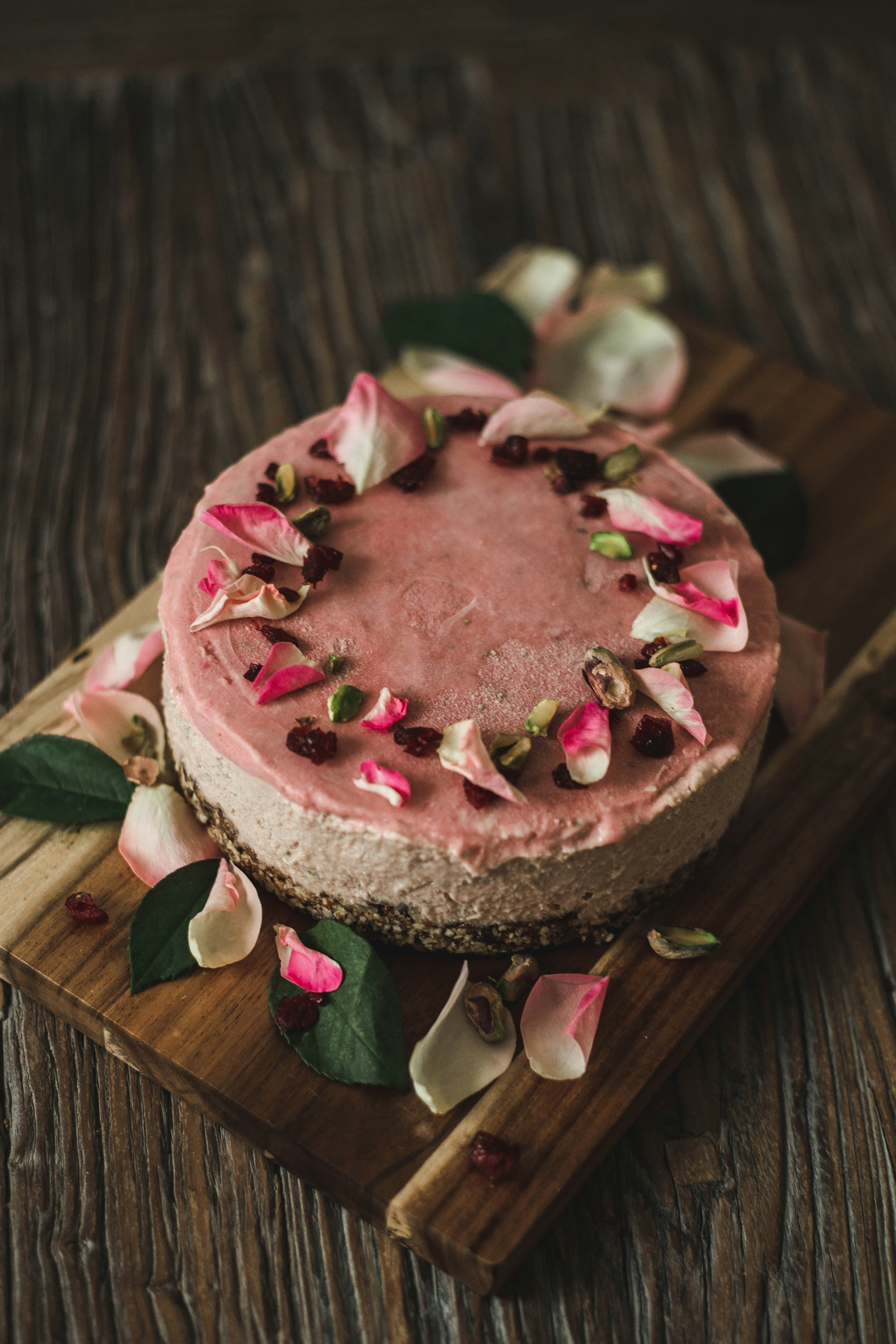 A cake with pink frosting and flowers on a wooden board photo – Free ...