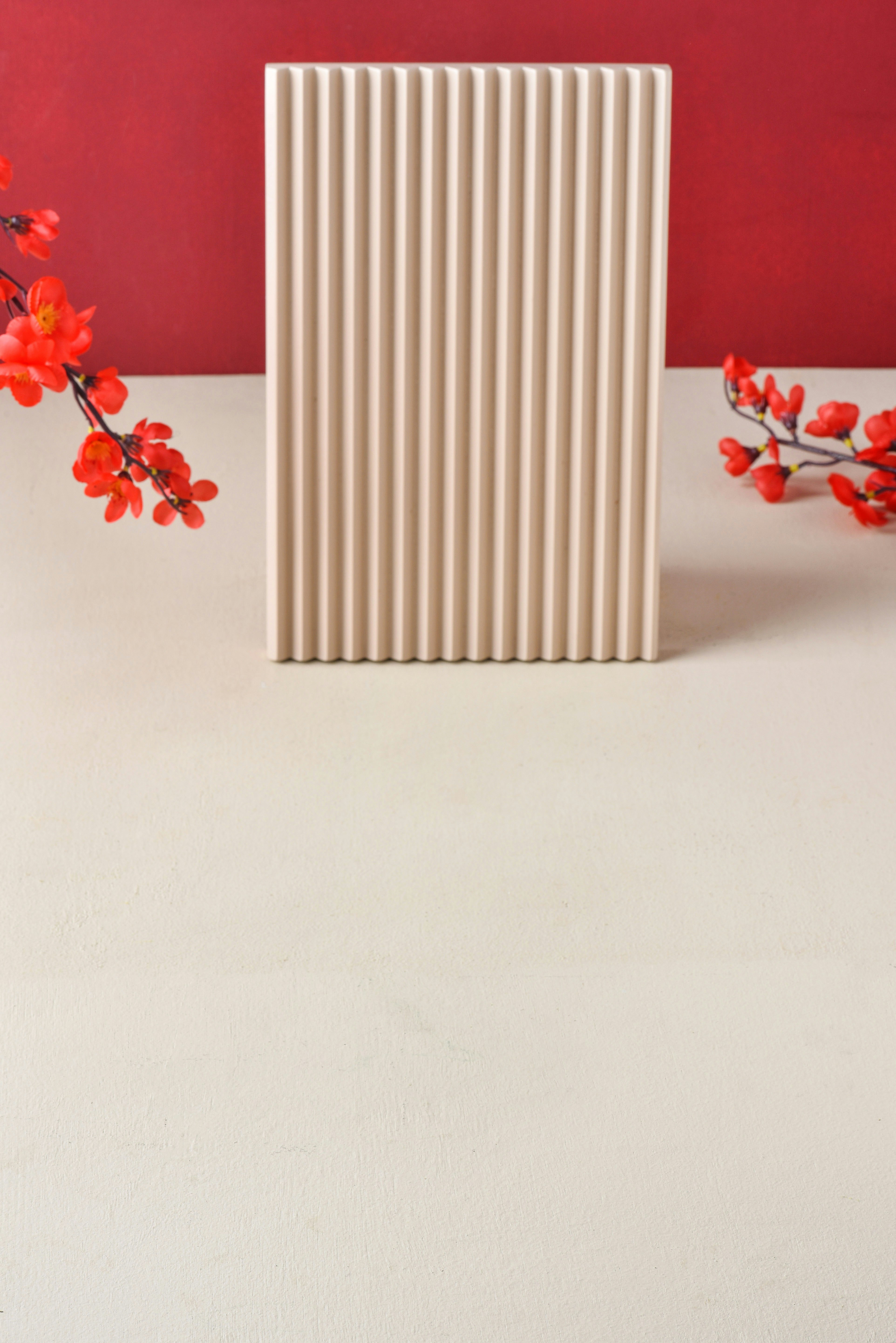 A white radiator sitting on top of a table next to red flowers photo ...