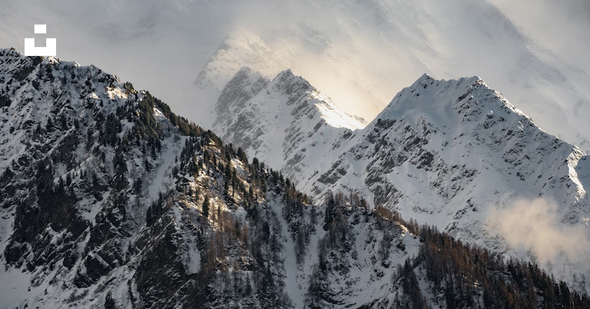 Une Montagne Couverte De Neige Et De Nuages Sous Un Ciel Nuageux Photo