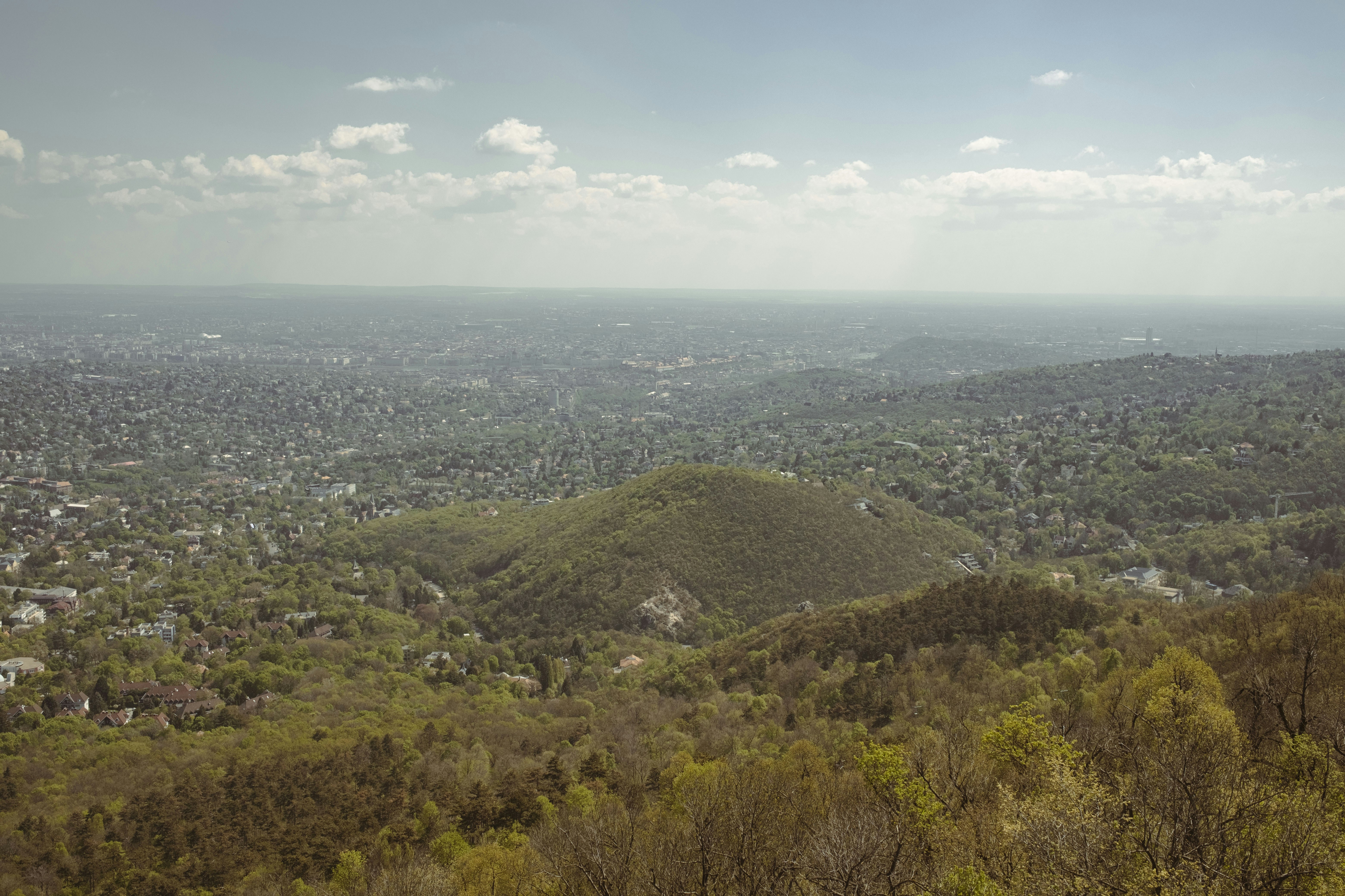 Emerald Crest Over a Quiet Valley: Hilltop to Cityscape