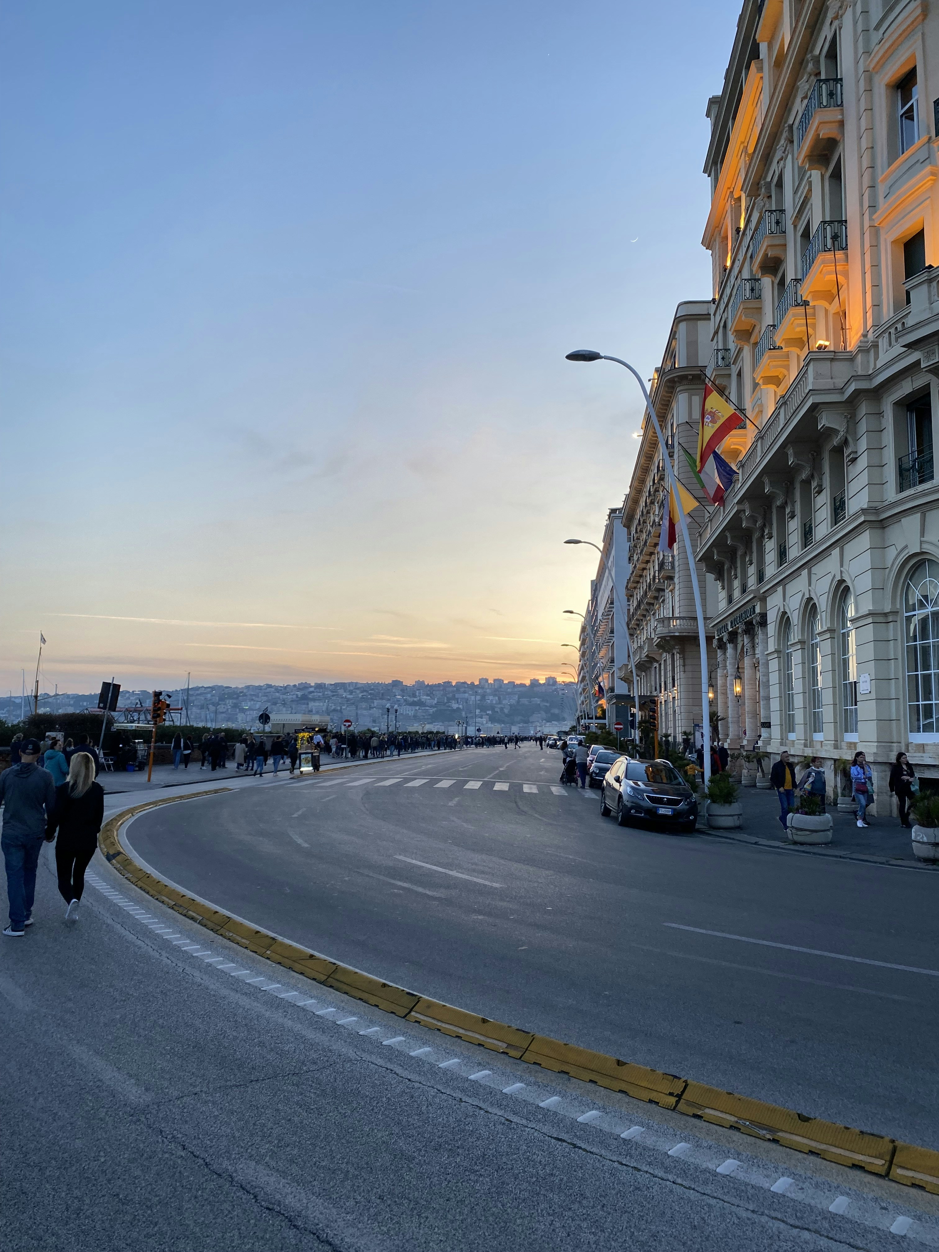 Dusk Along the Grand Avenue: Flags, Facades, and the Gentle Curve of a City Street