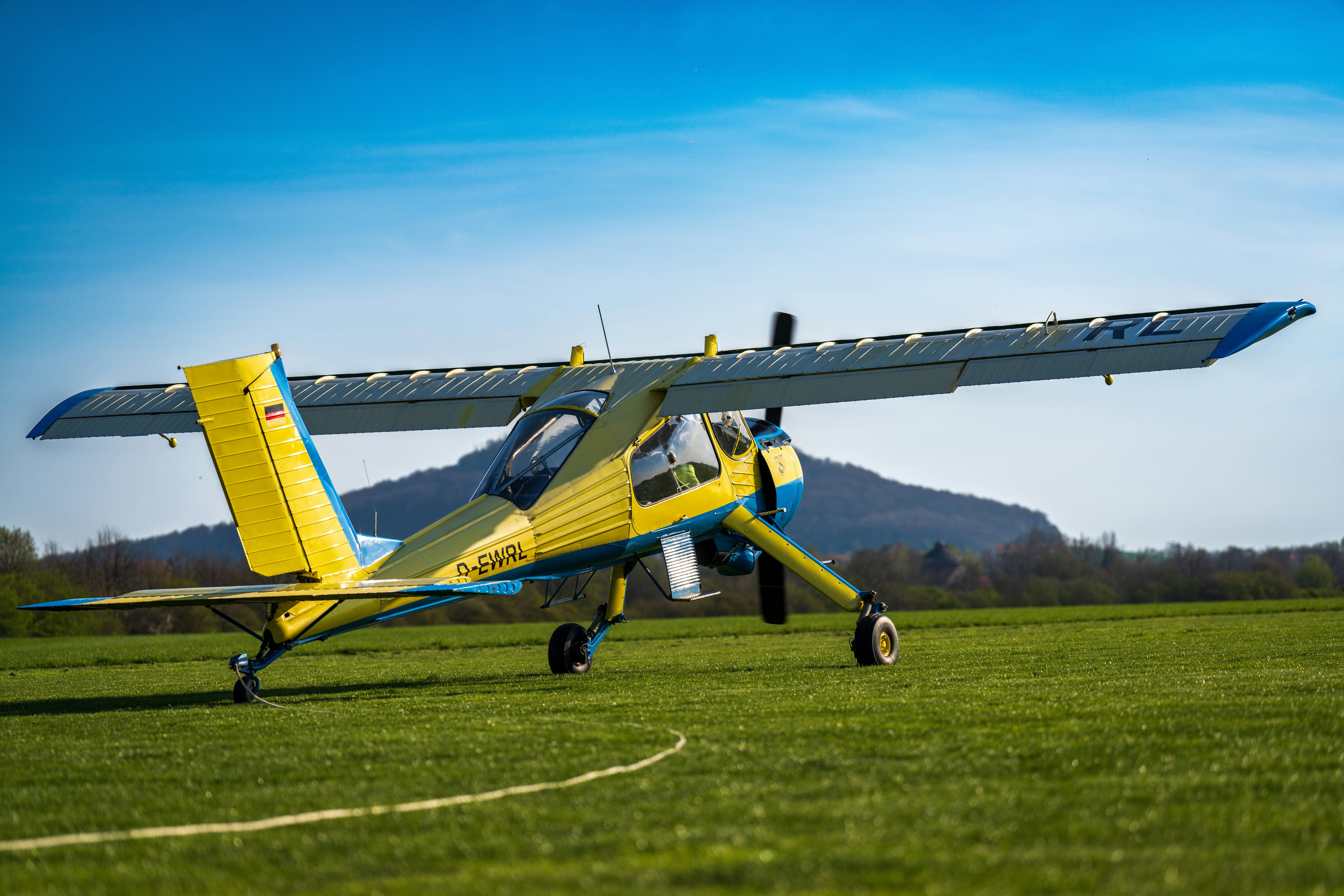 A small yellow and blue plane on a grassy field photo – Free Görlitz ...